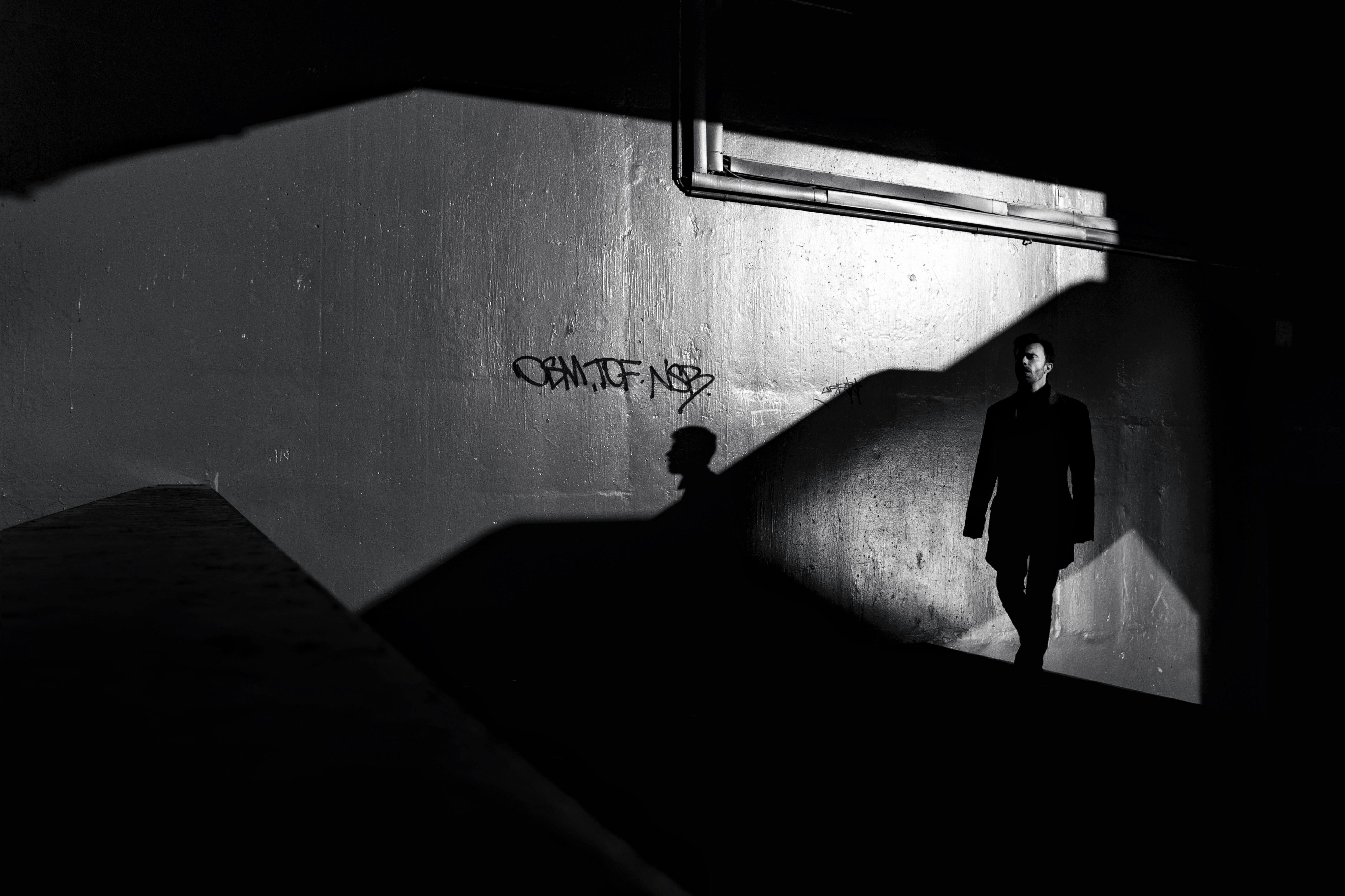 Man Standing in the Shadow on the Background of a Wall · Free Stock Photo