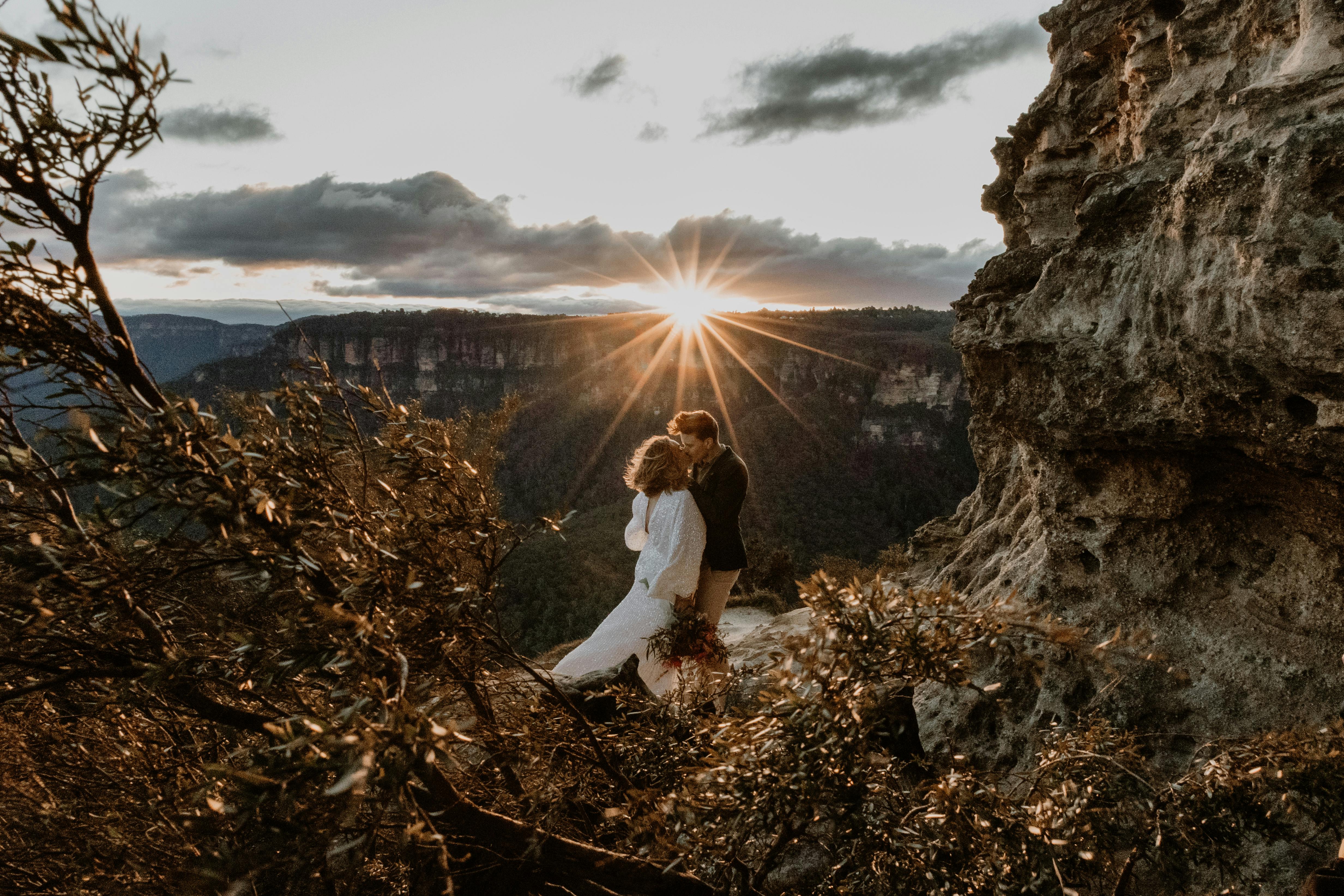 Couple Kissing near Rocks at Sunset · Free Stock Photo