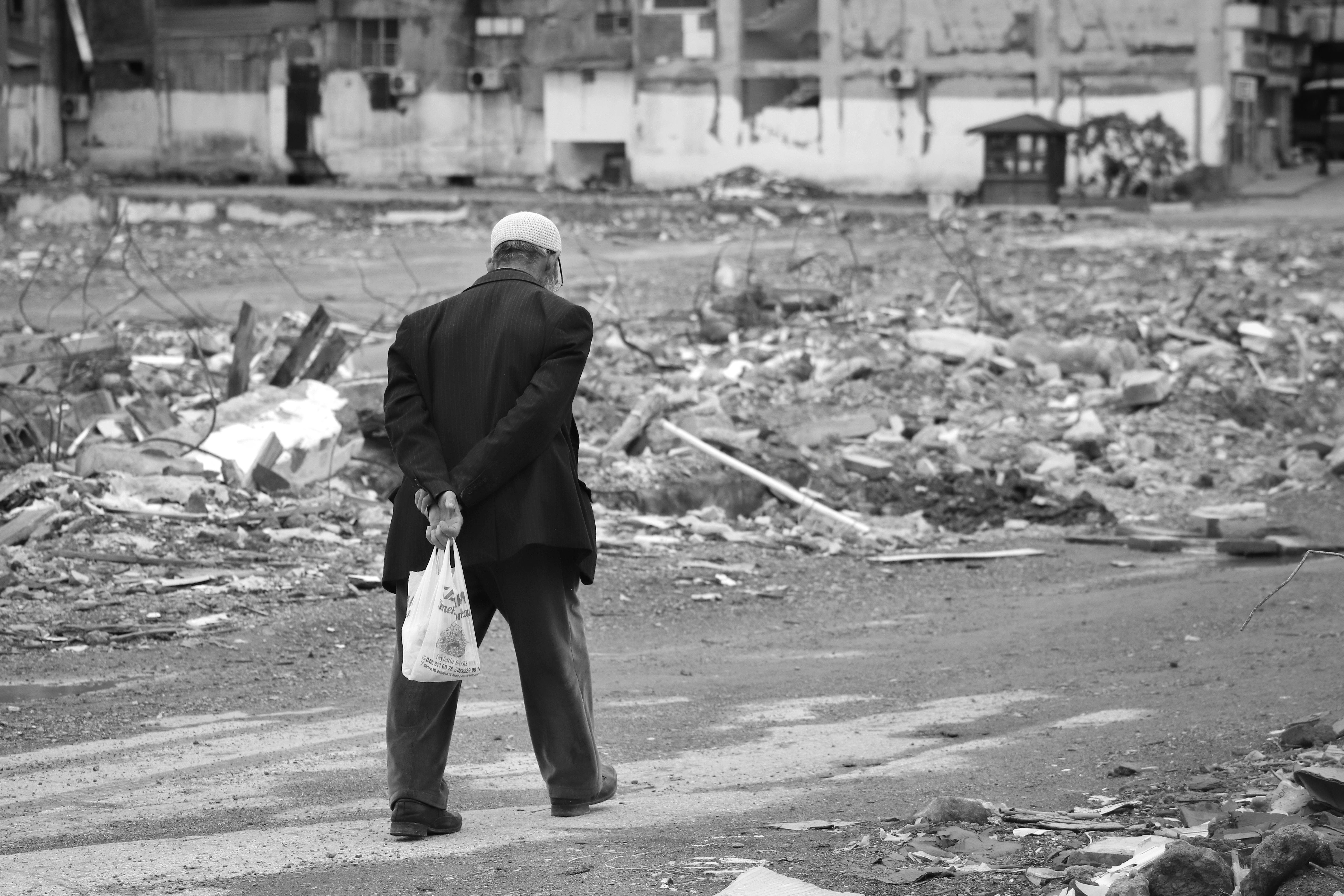 Old Man Walking on Destroyed City Ruins · Free Stock Photo