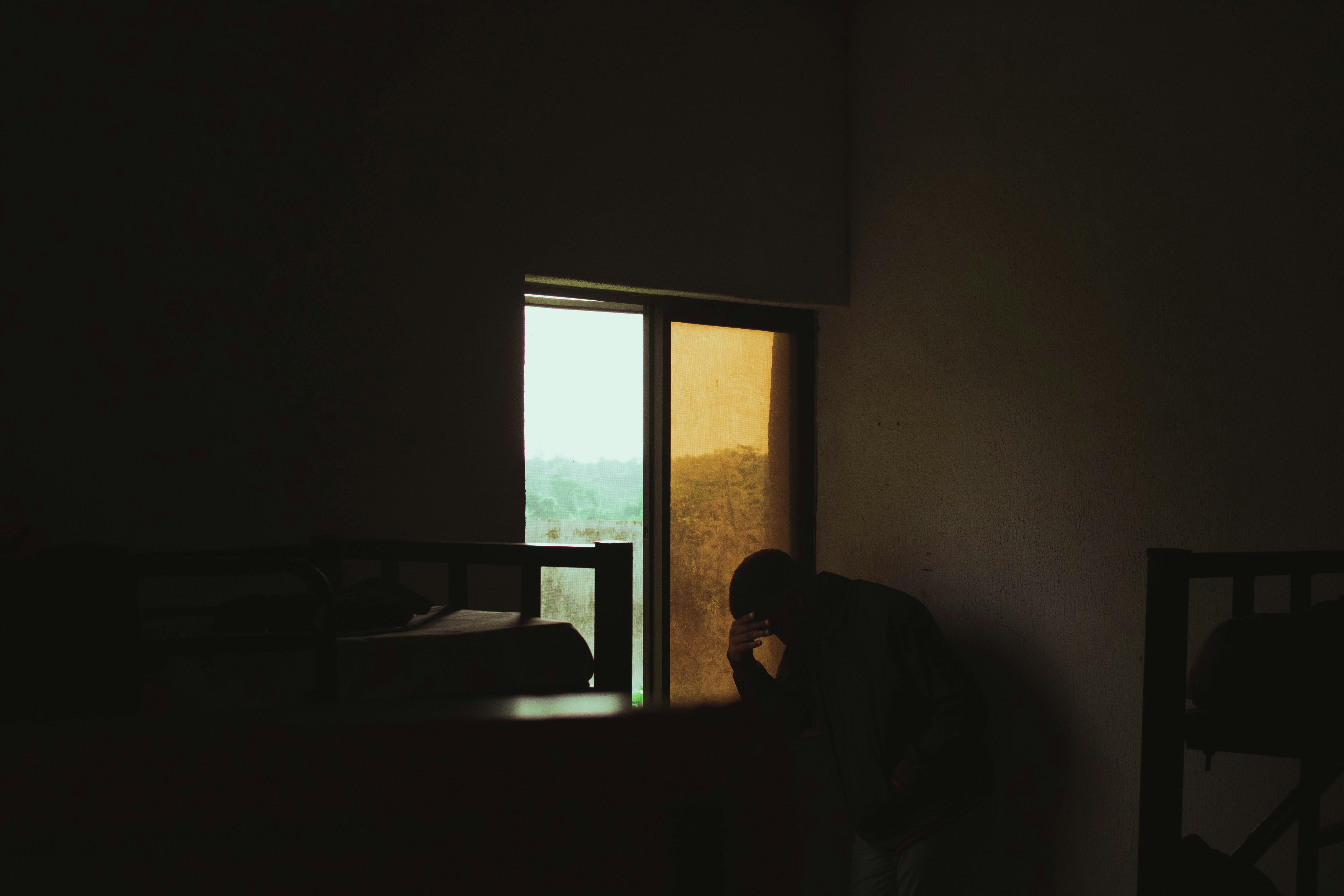 Silhouette of a Man Standing by the Window in a Room · Free Stock Photo