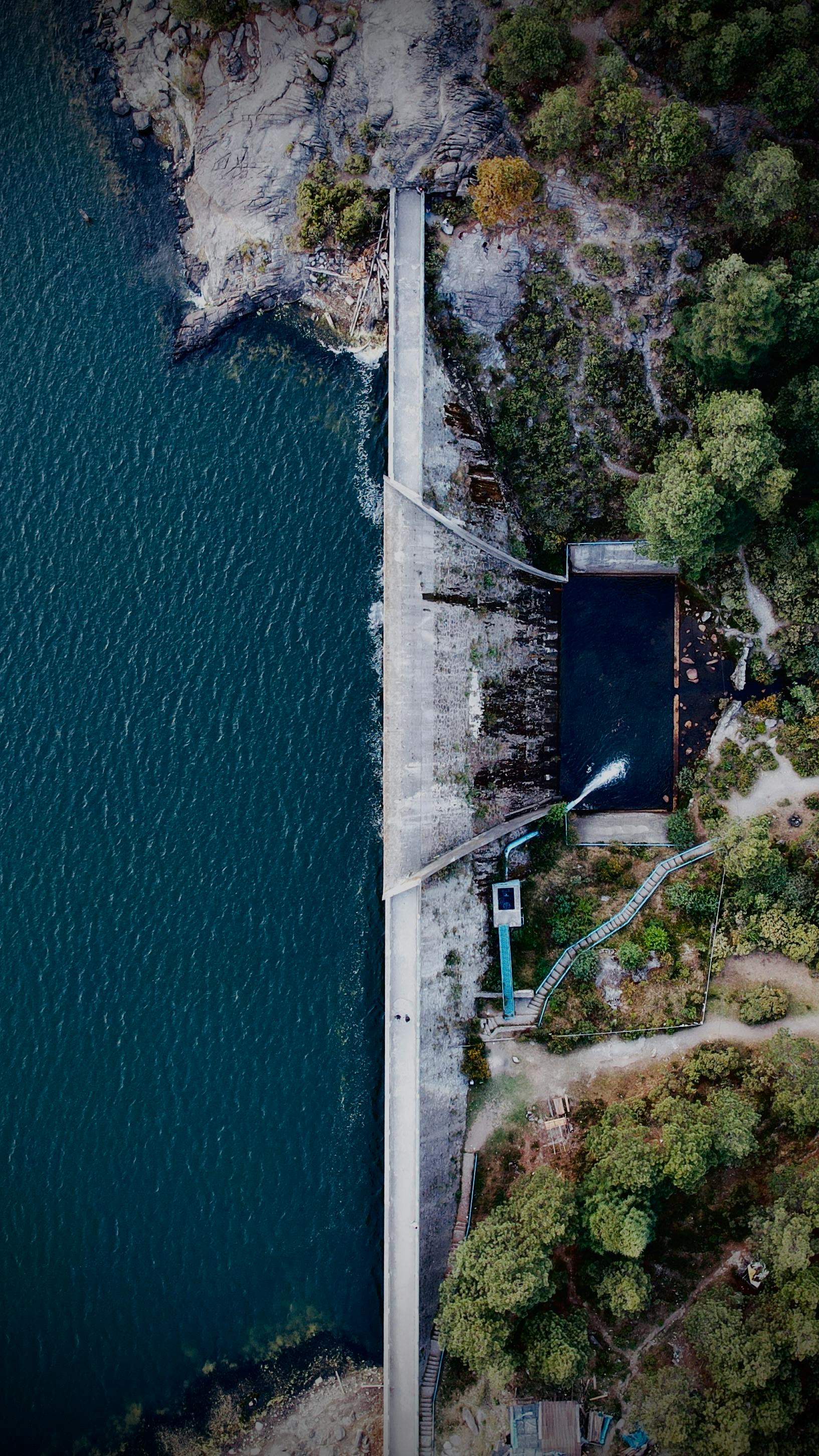 Top View of a Dam, Trees and Cliffs on the Shore · Free Stock Photo