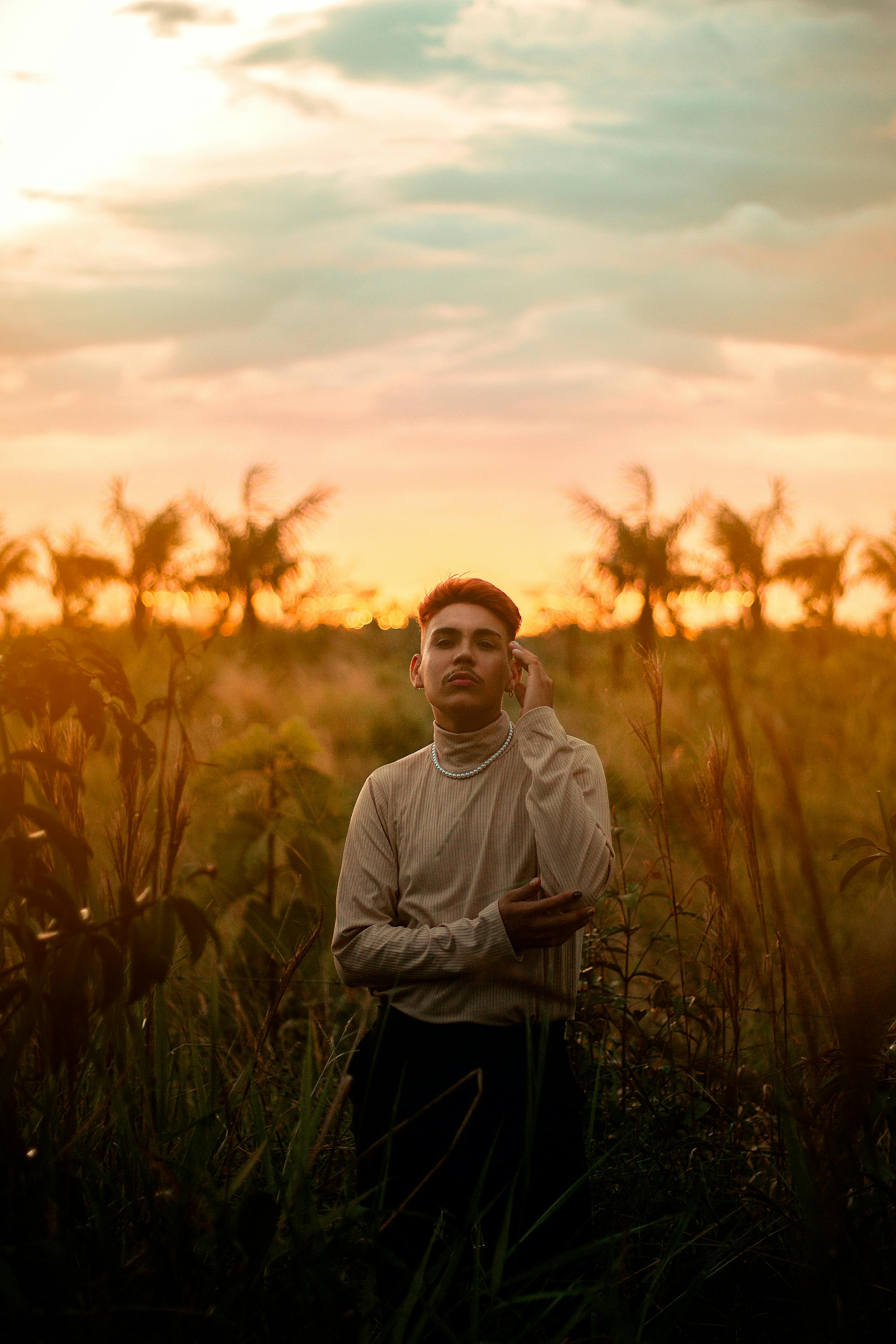 Young Man Standing on a Meadow with Palm Trees in the Background · Free ...