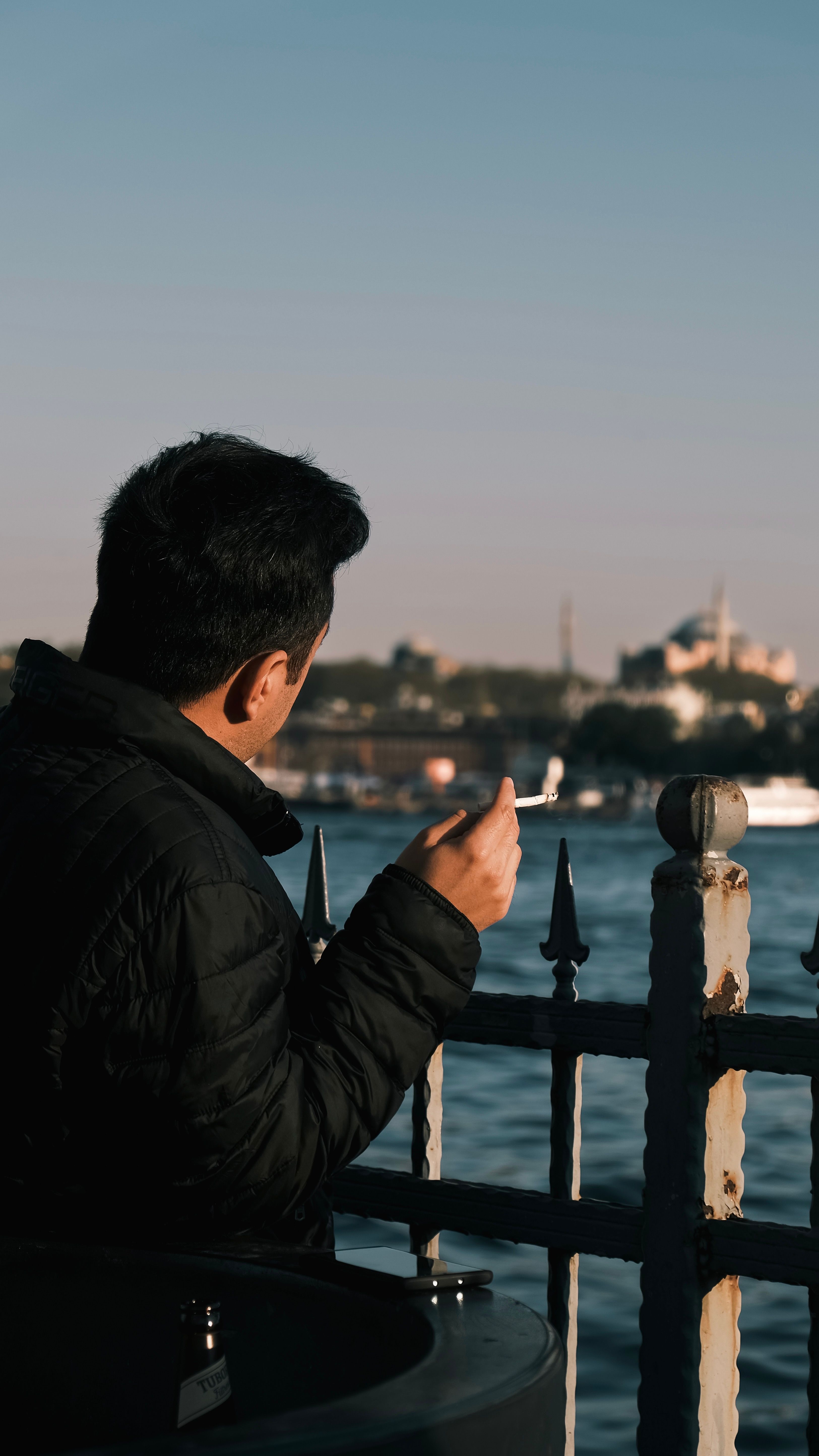 Back of a Man Smoking a Cigarette at the Coast · Free Stock Photo