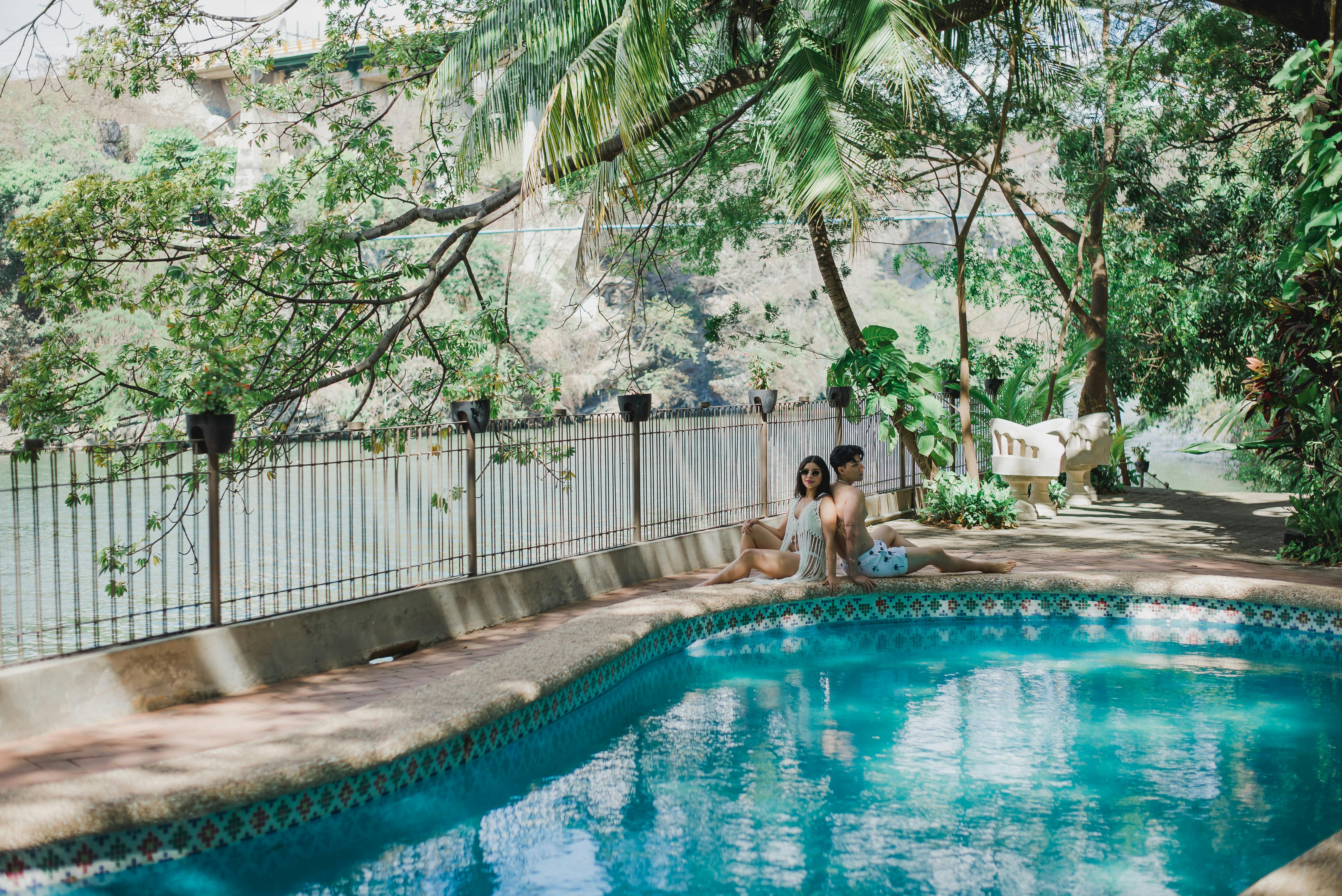 A Couple Sitting by a Pool · Free Stock Photo