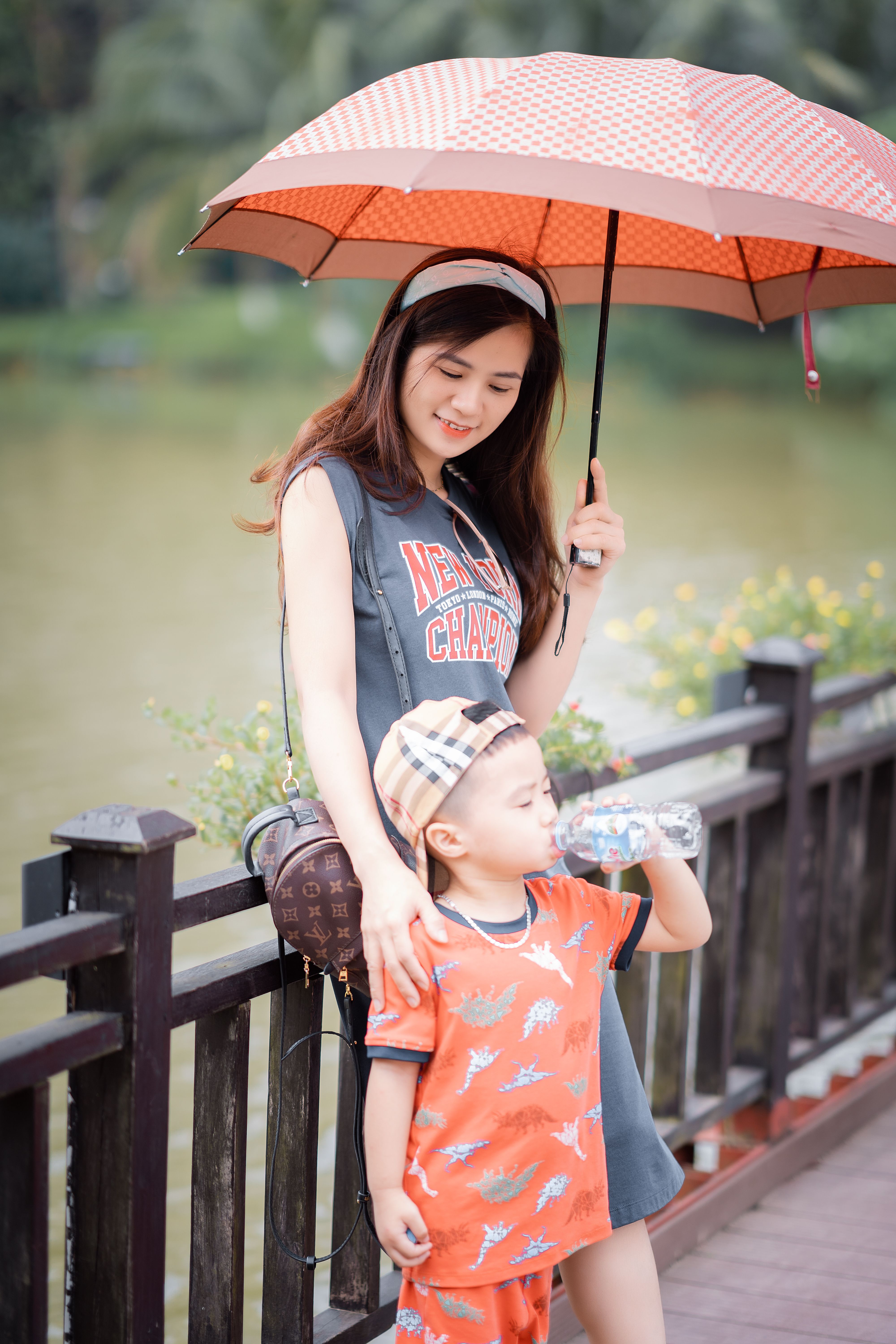 Mother Shielding Her Little Son Under an Umbrella · Free Stock Photo