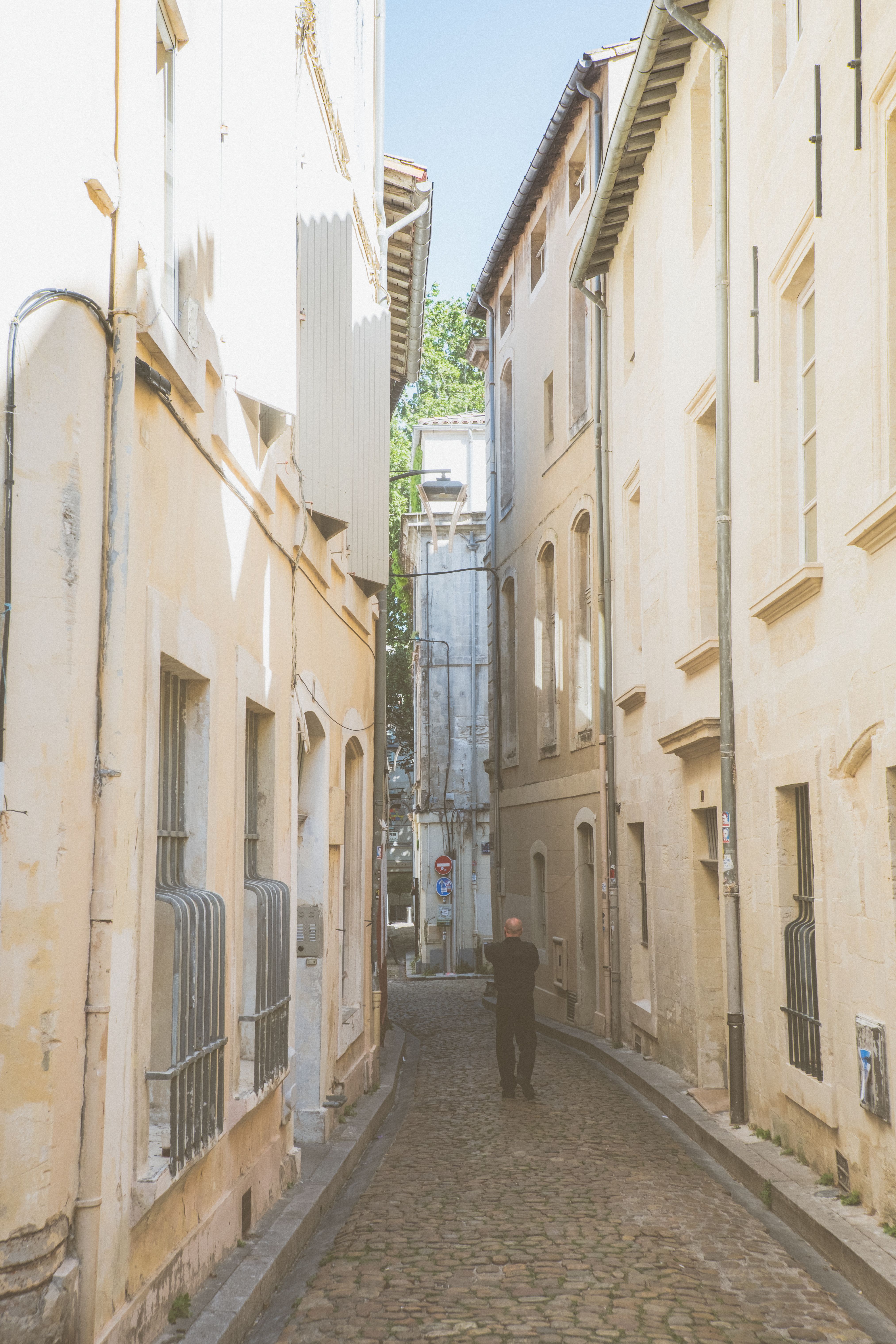 Man Walking on Narrow Paving Street · Free Stock Photo