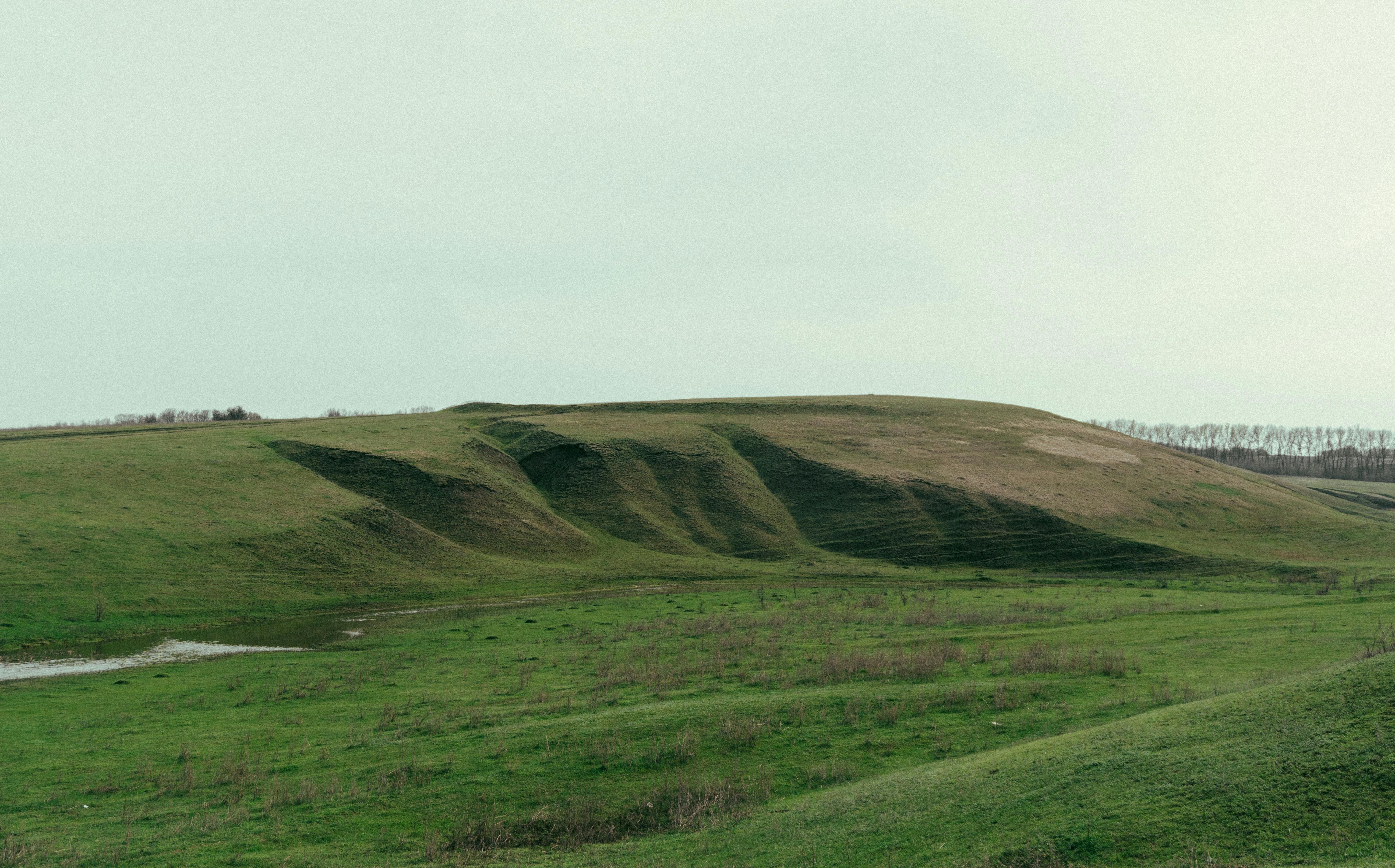 Green Grassland with Stream and Hill behind · Free Stock Photo