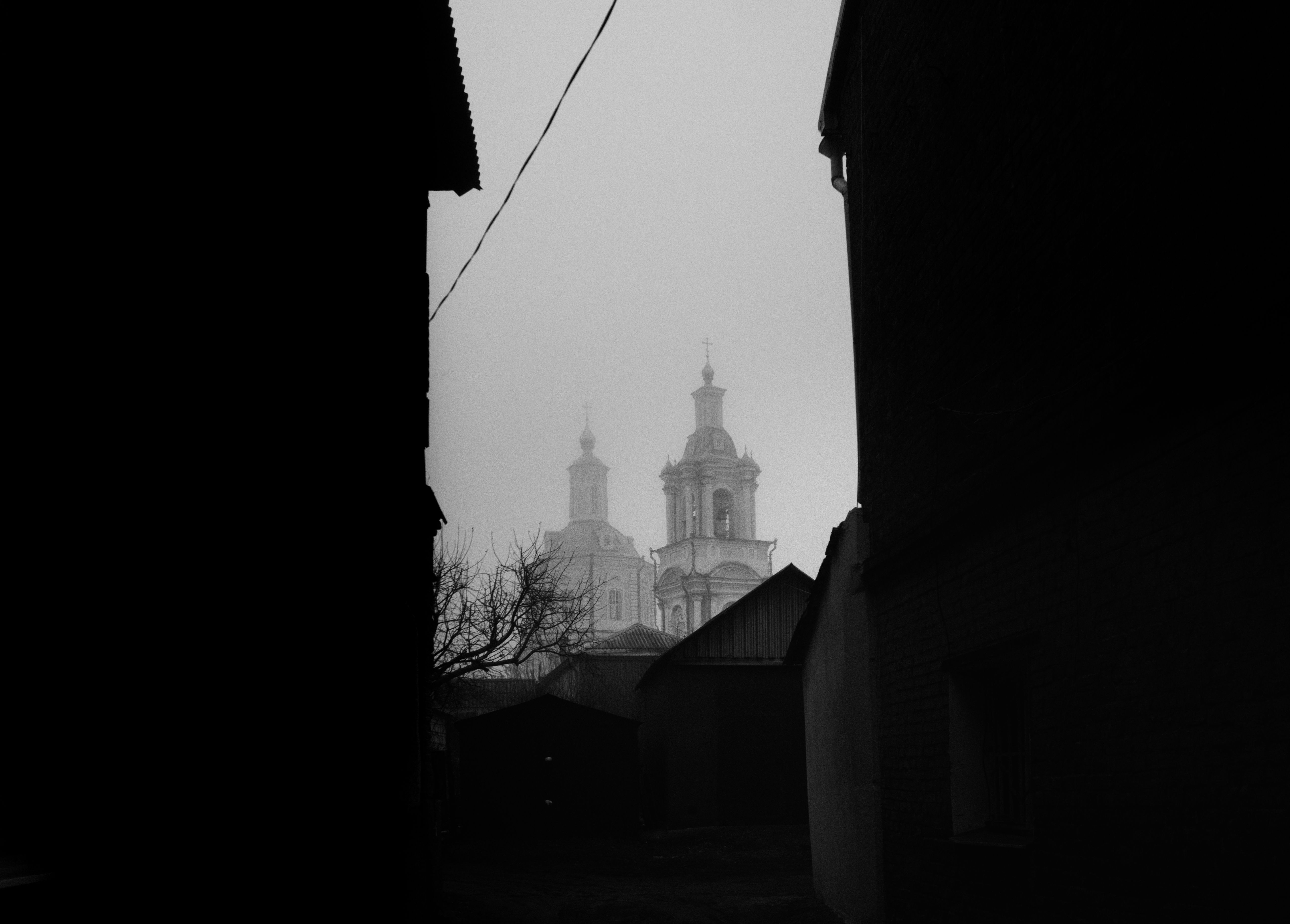 Church Towers behind Buildings in Town · Free Stock Photo