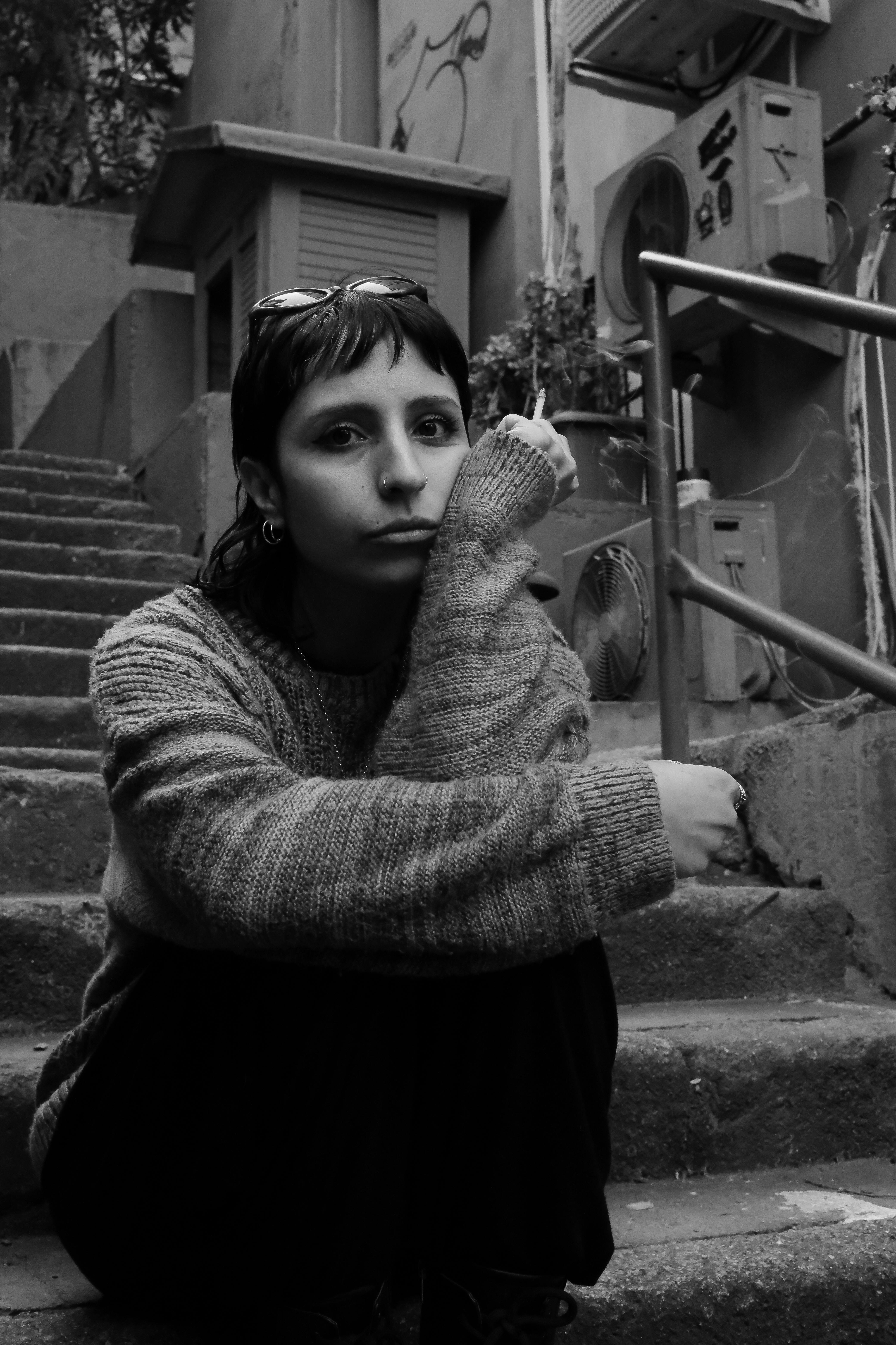 Woman Sitting on Steps in City and Smoking Cigarette · Free Stock Photo