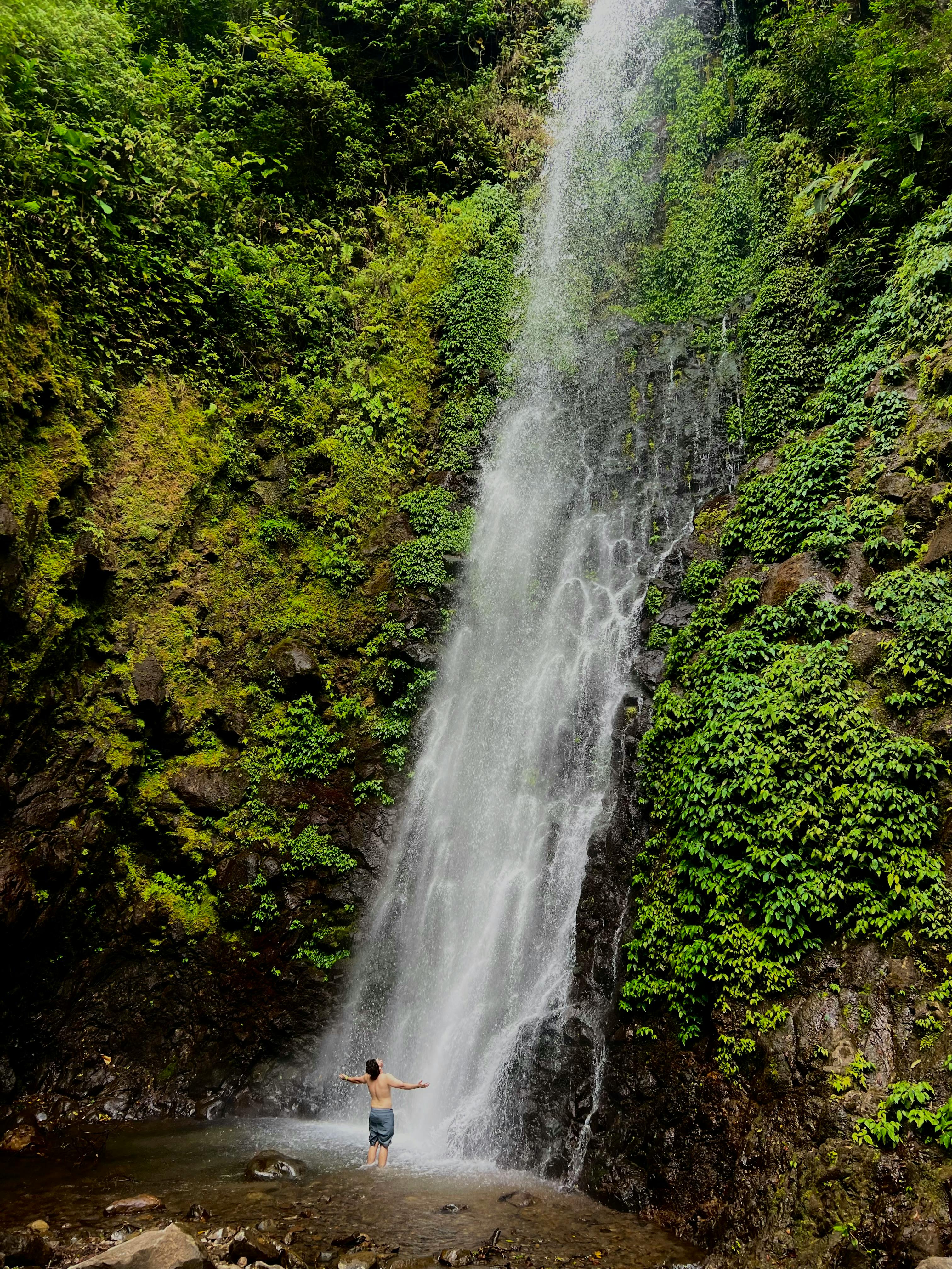 Man Stands under Waterfall · Free Stock Photo