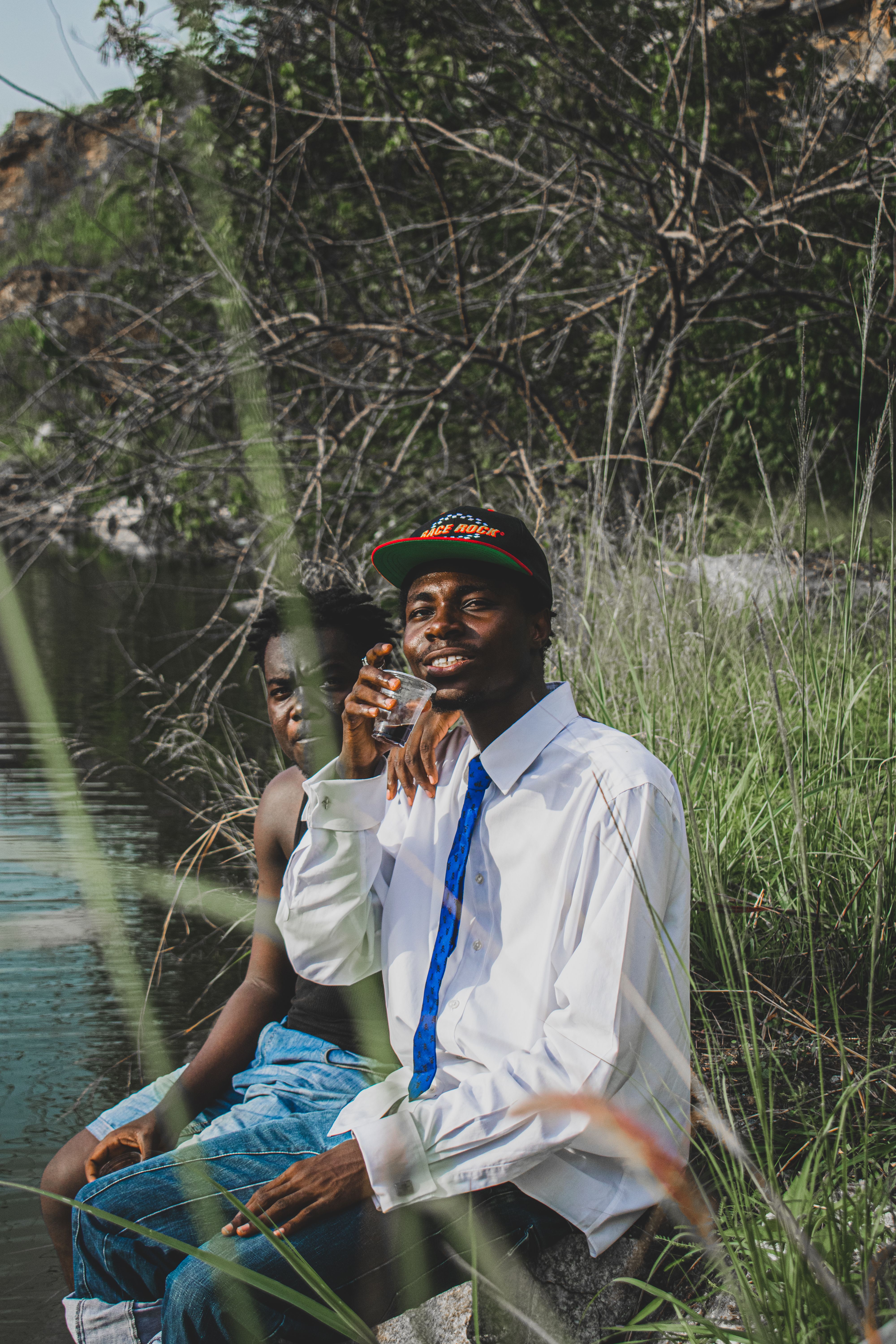 Men Sitting on Riverbank · Free Stock Photo