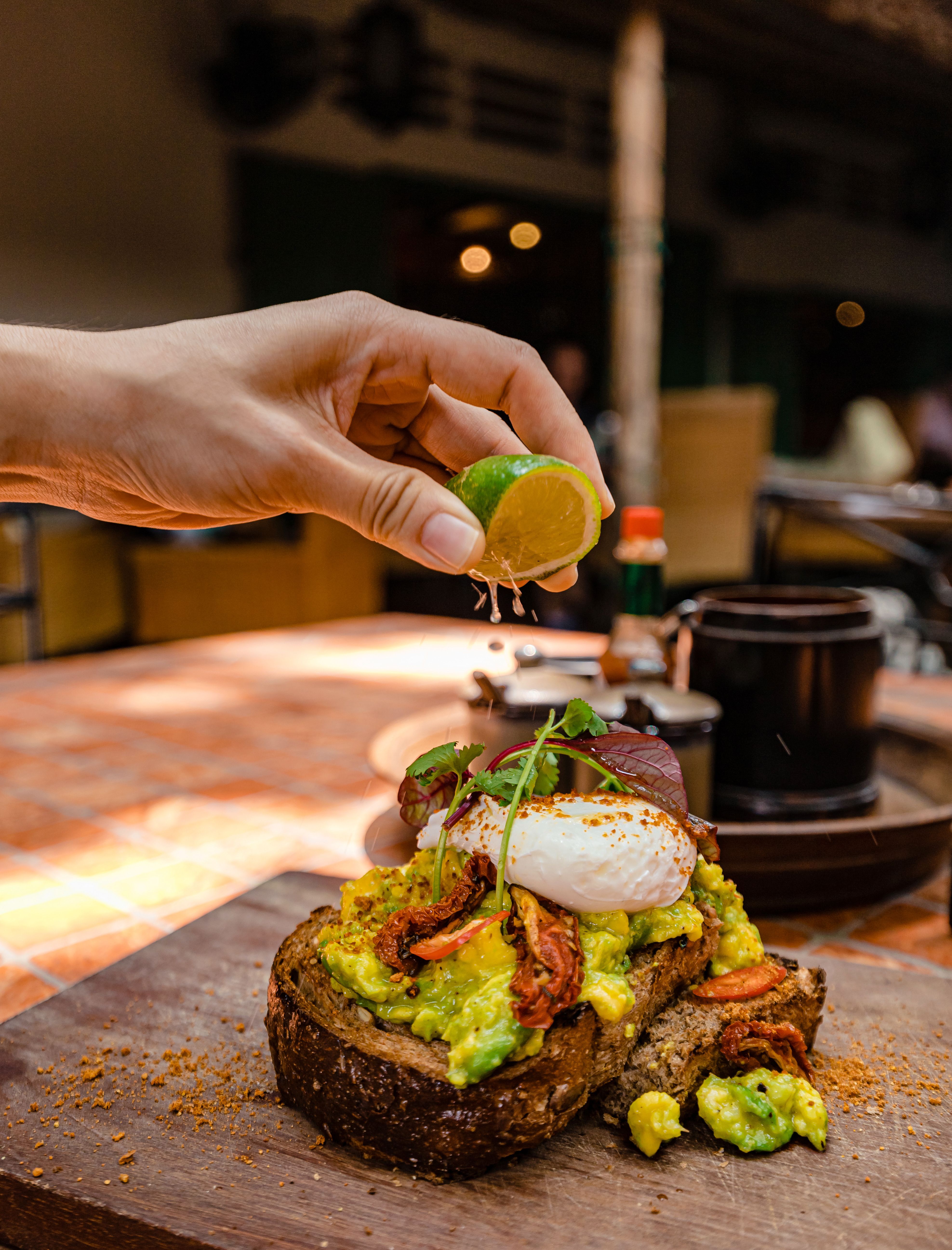 Person Squeezing Lime on Vegetable Wrap · Free Stock Photo