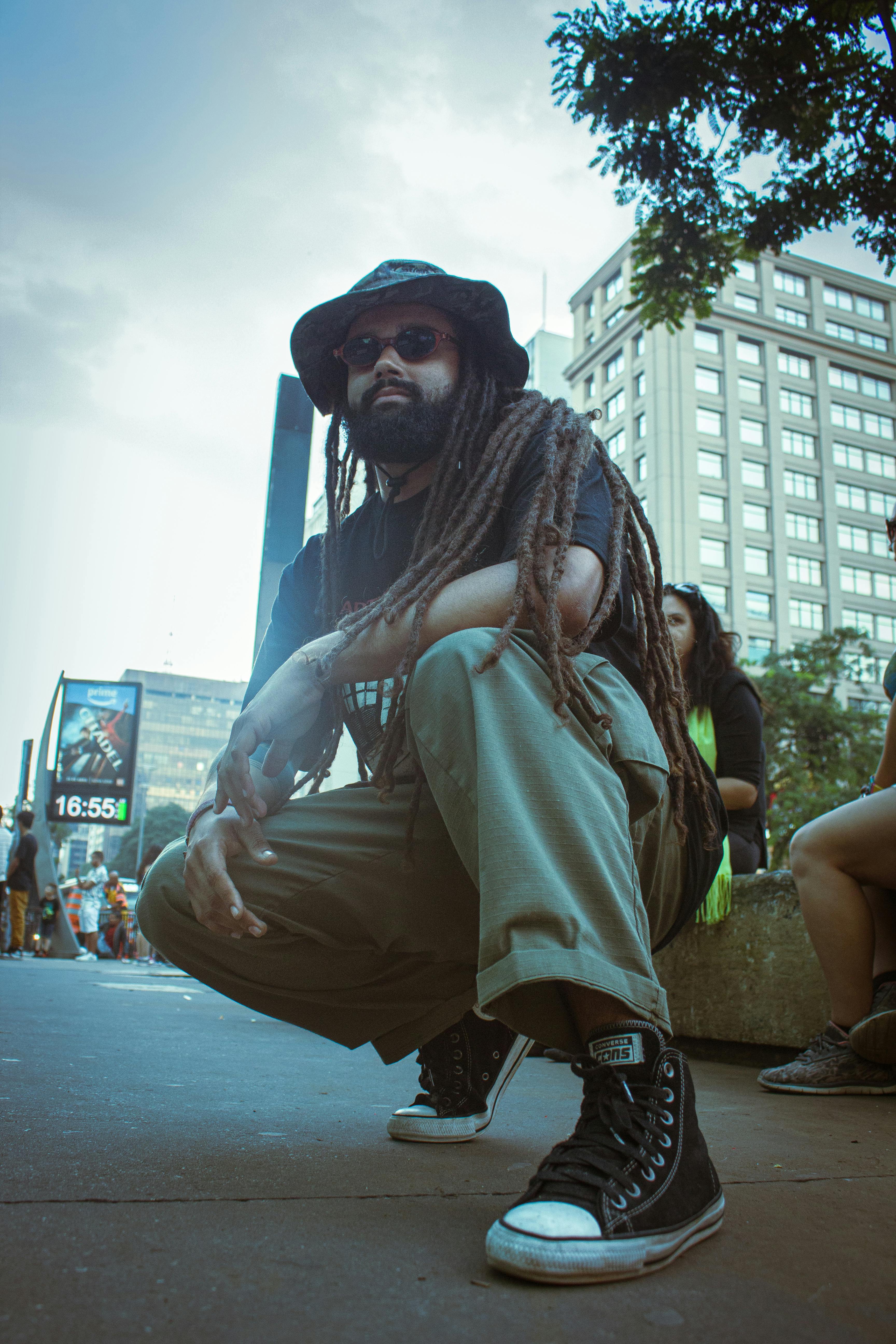 Crouching Man with Dreadlocks · Free Stock Photo