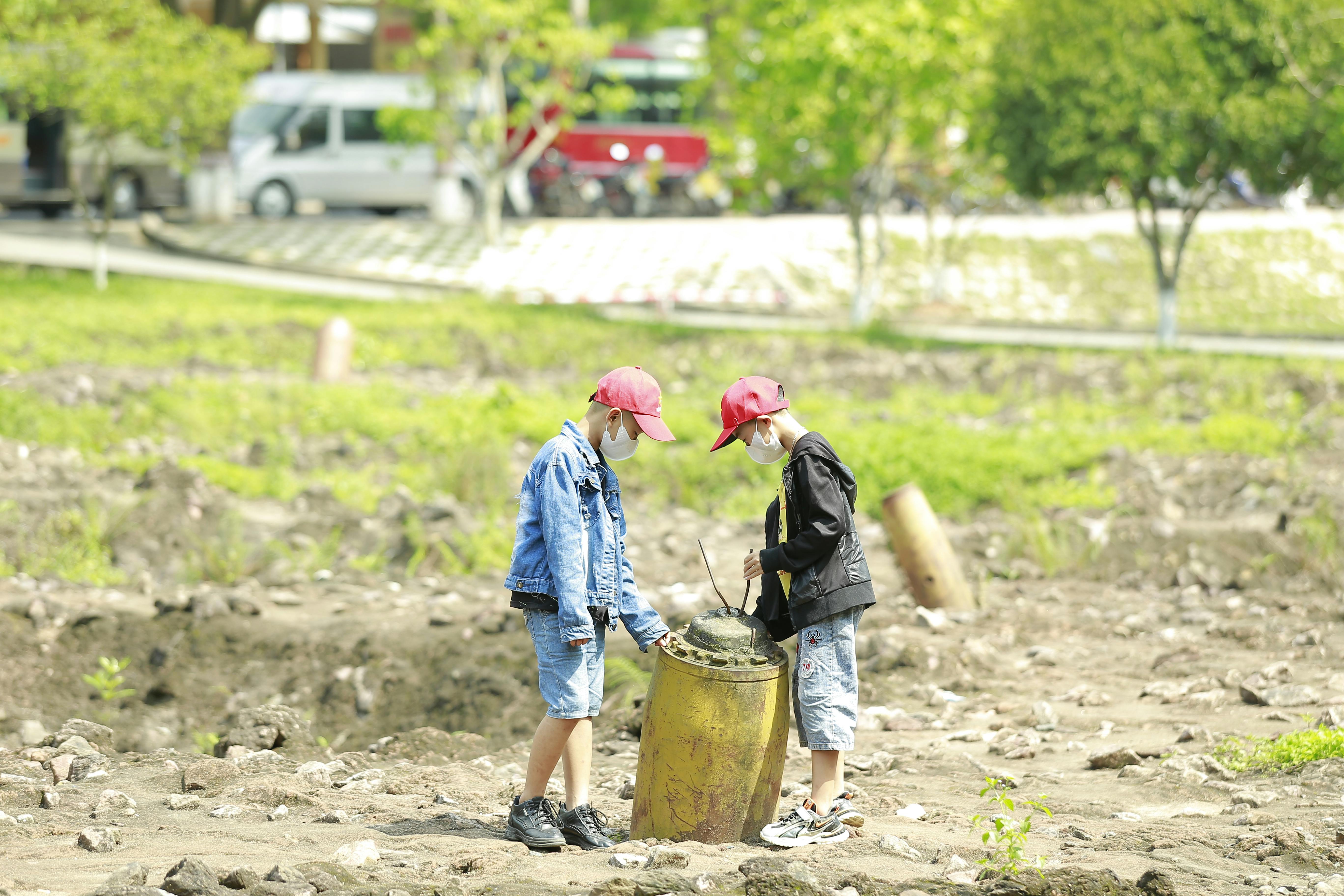 Young Boys in Face Mask Standing on a Field next to a Barrel · Free ...