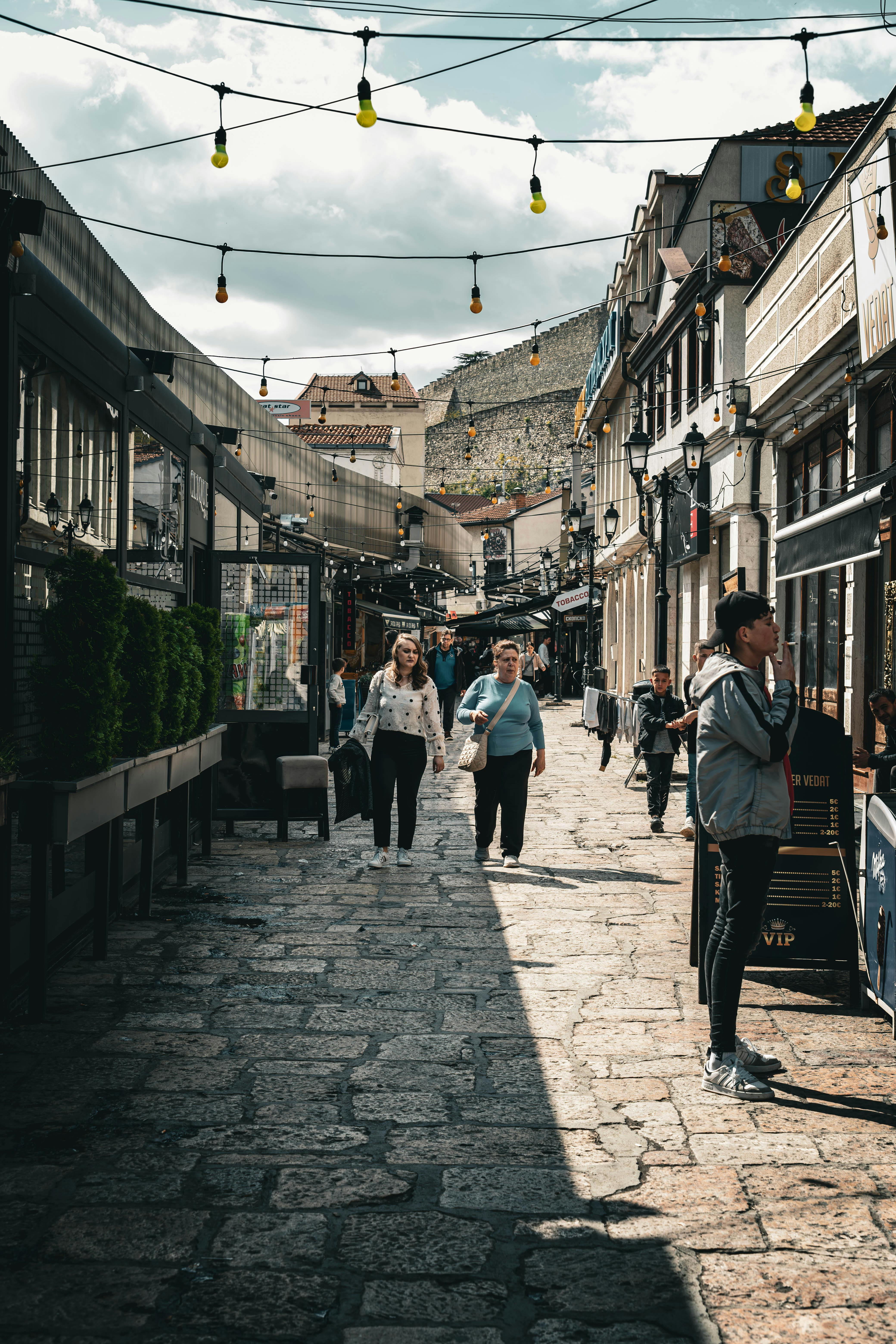 Busy narrow paved street with people · Free Stock Photo