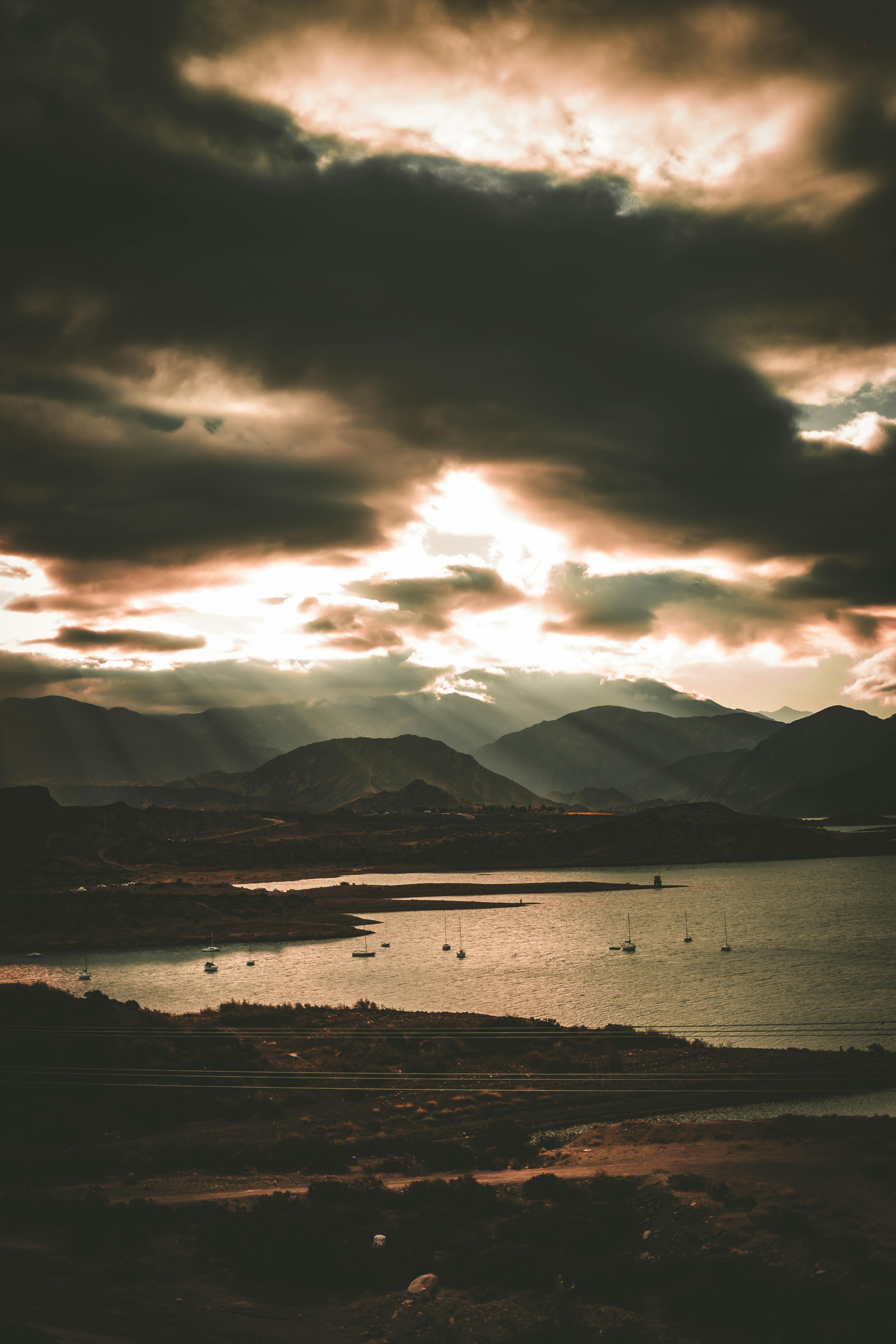 Dramatic Cloudy Sunset Sky over Water and Mountains · Free Stock Photo