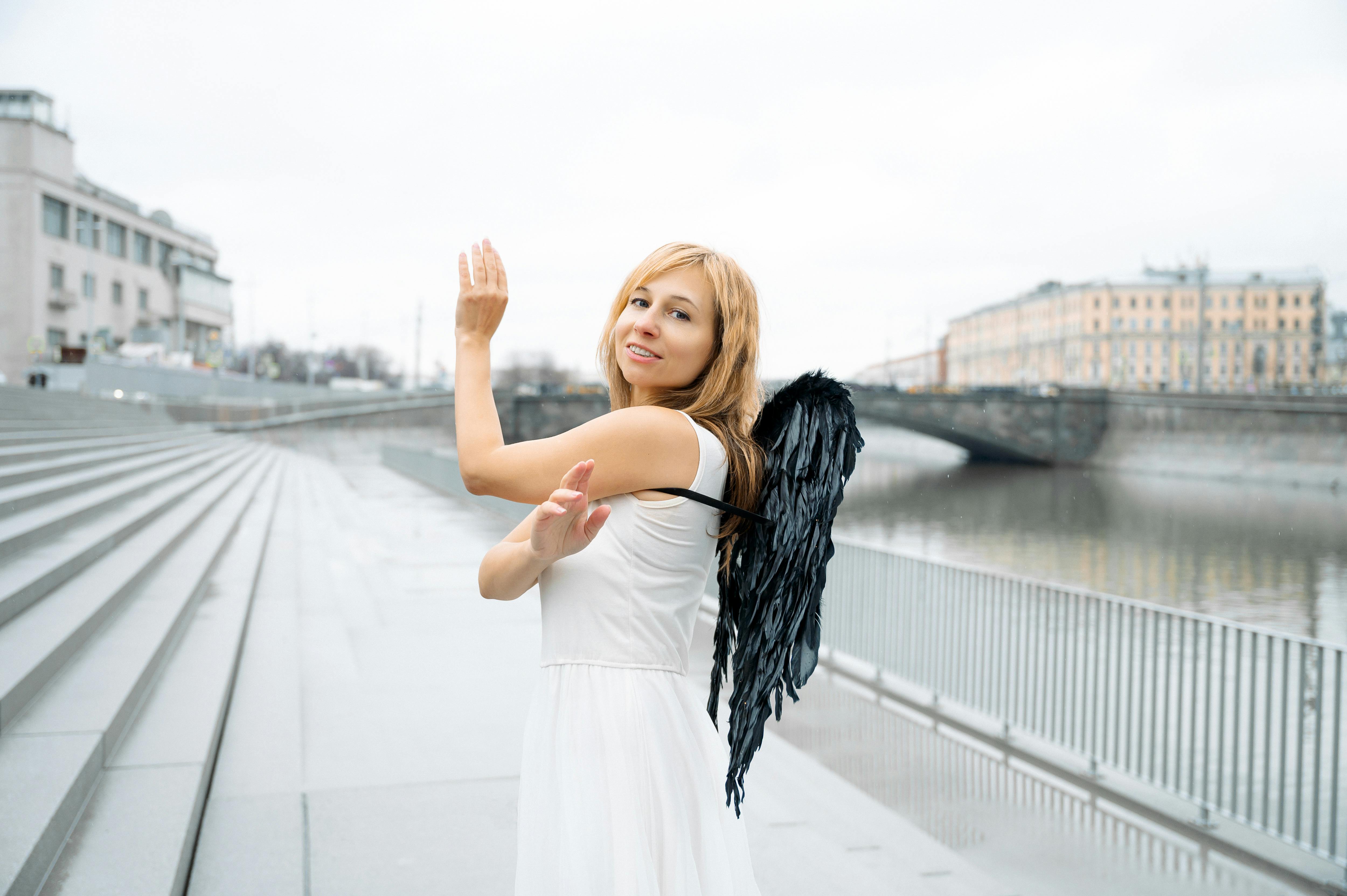 Smiling Blonde with Black Wings Looking Over Her Shoulder · Free Stock ...