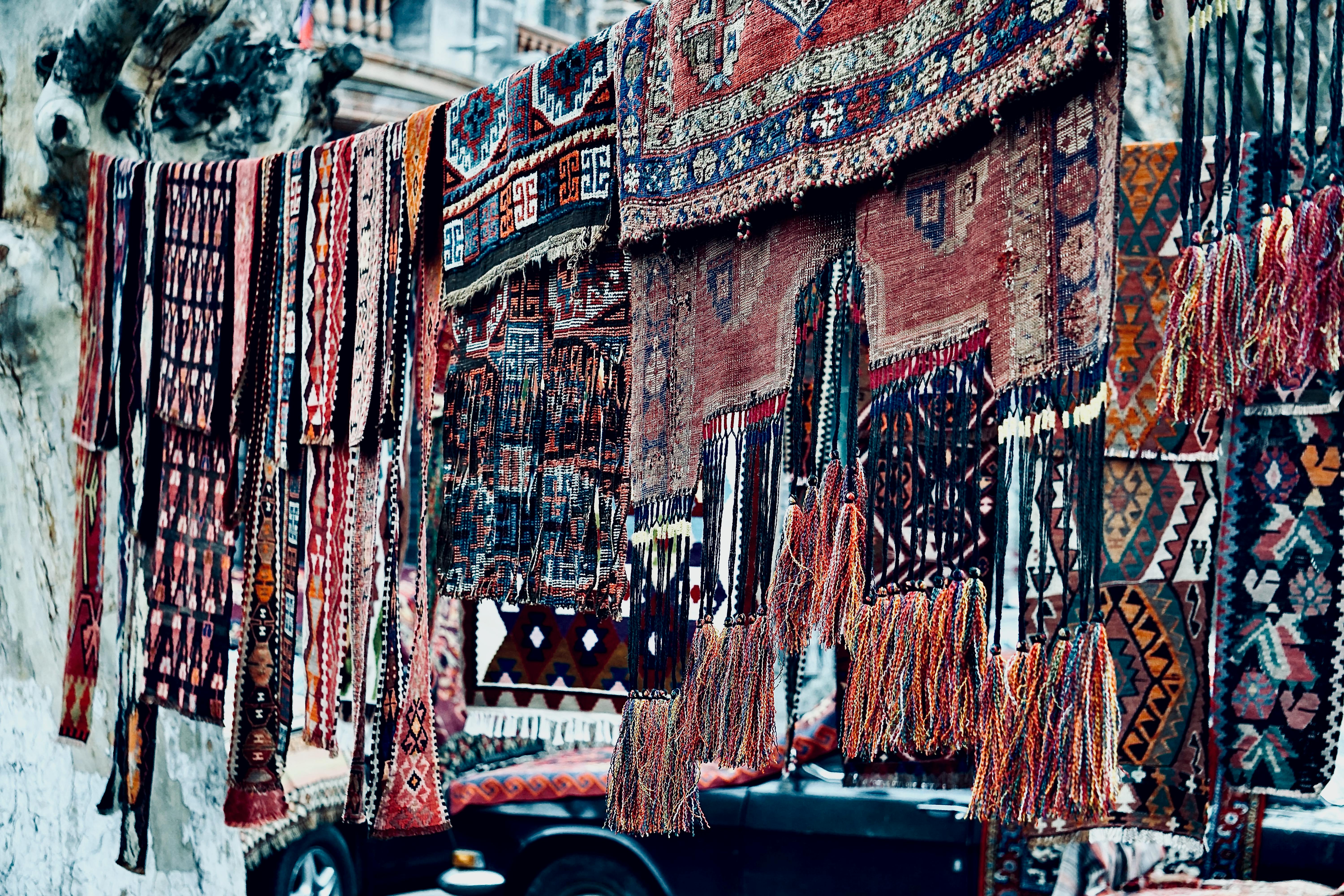 A row of colorful rugs hanging on a wall · Free Stock Photo
