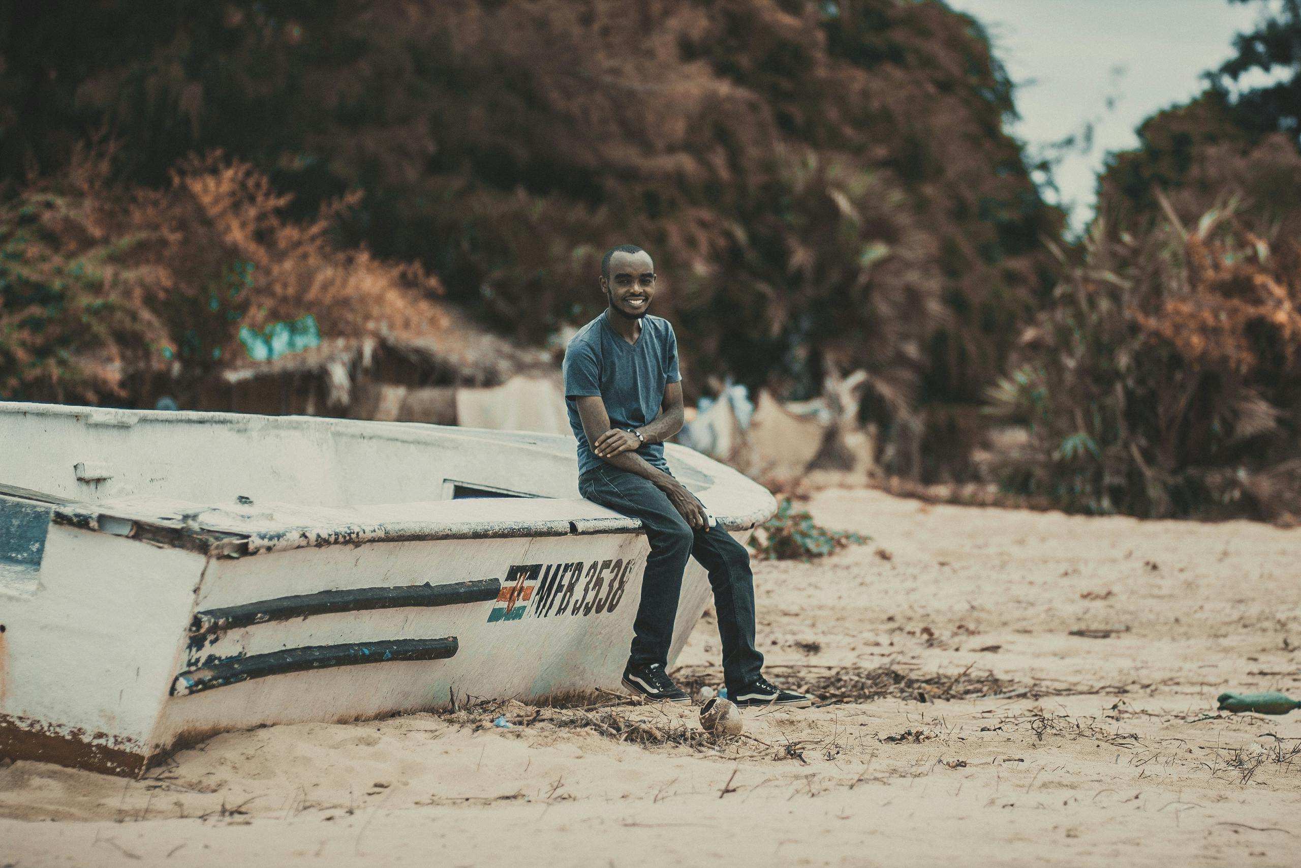 Man in Blue Top Sitting on Boat · Free Stock Photo