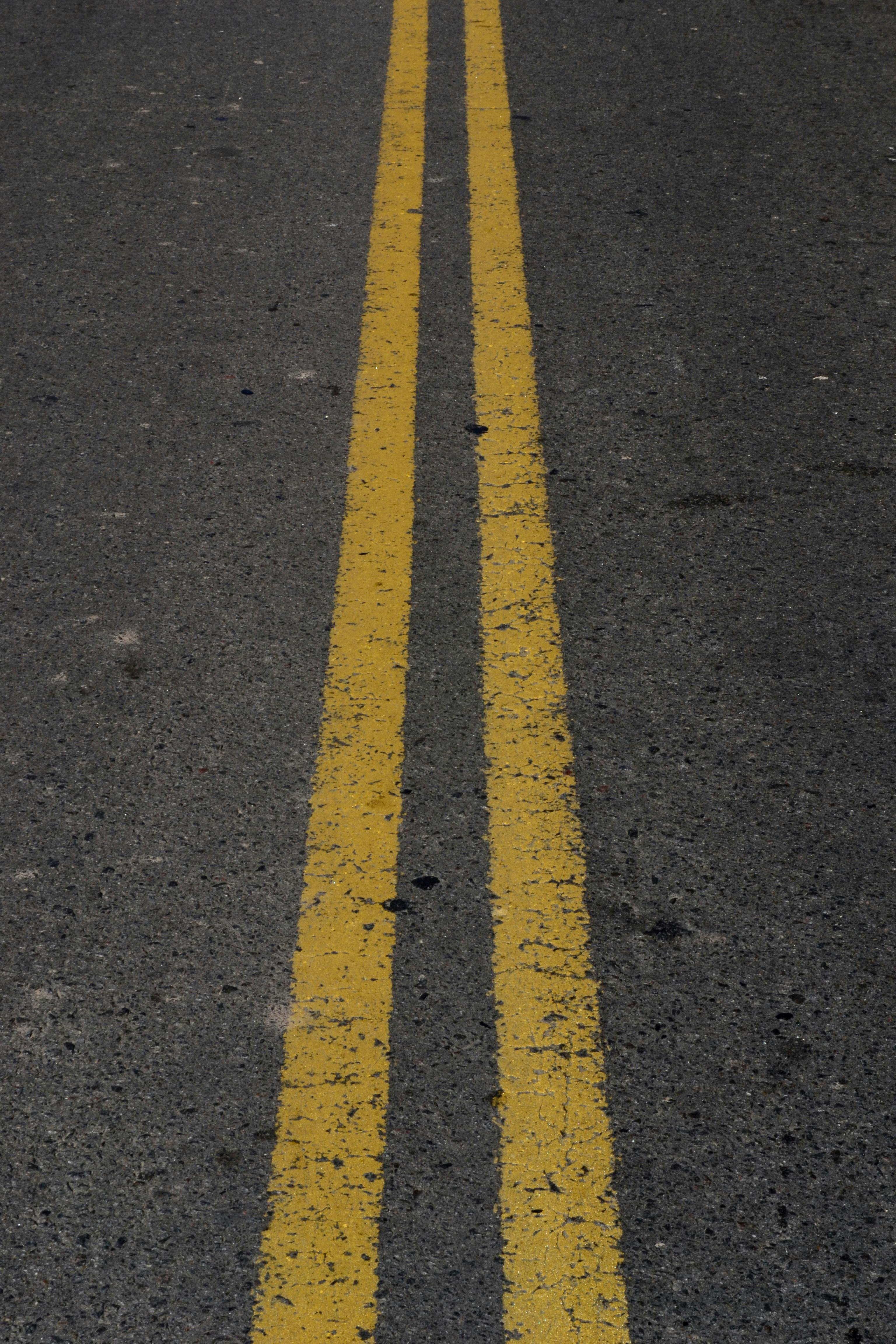 A Pair of Solid Yellow Line Markings on Asphalt Road · Free Stock Photo