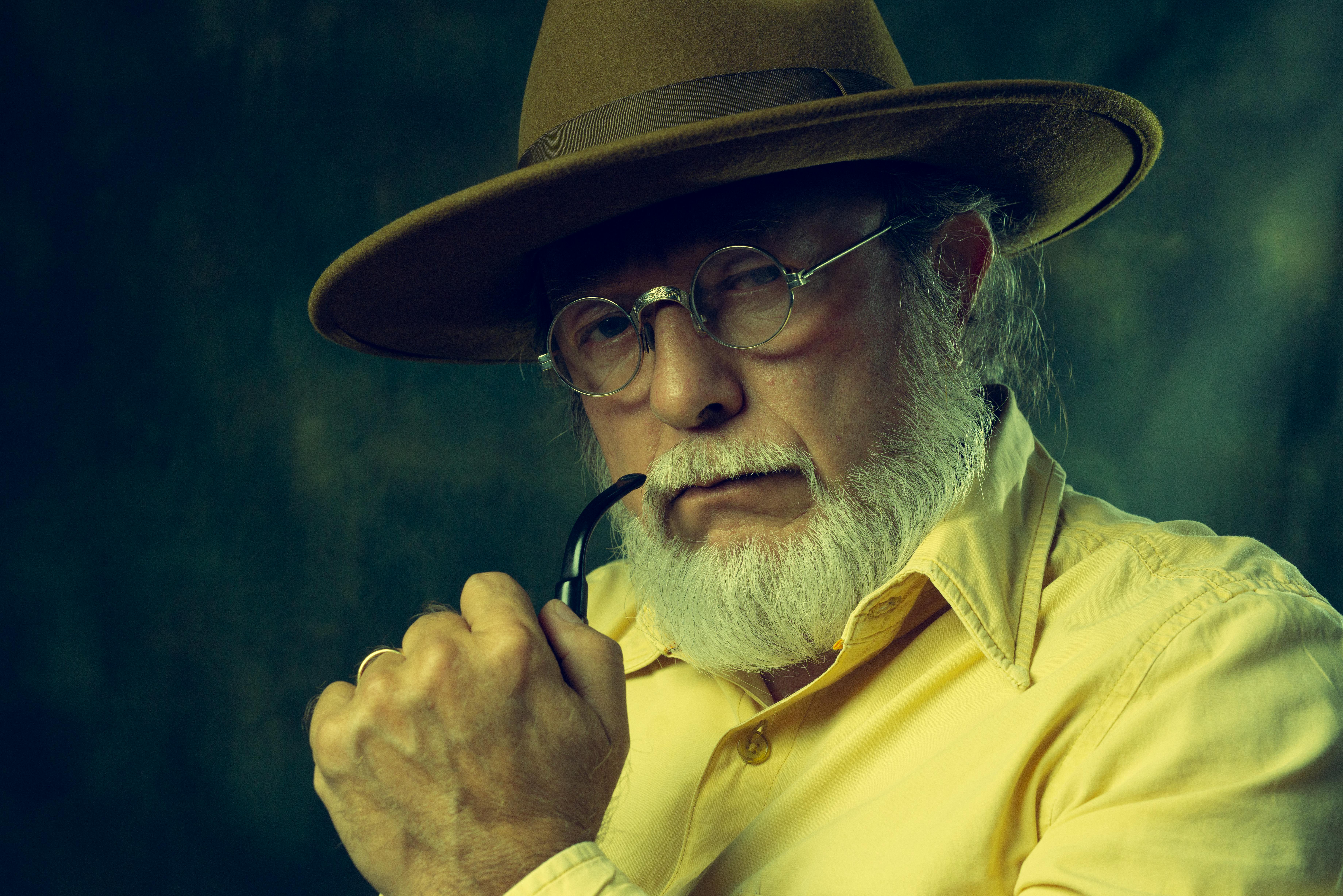 Man in Traditional Plume Smoking Pipe · Free Stock Photo