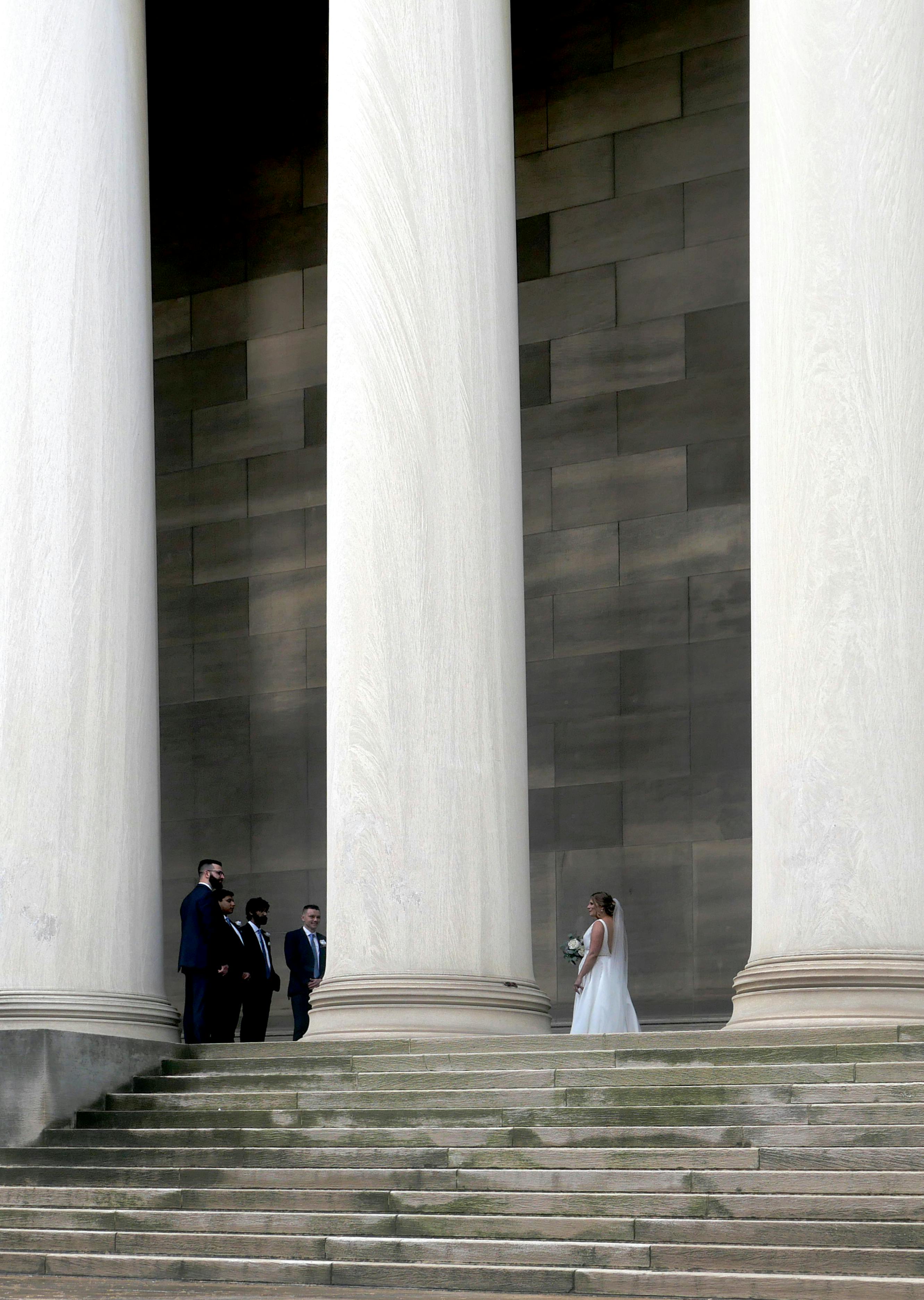 Bride Standing between Monumental Columns · Free Stock Photo