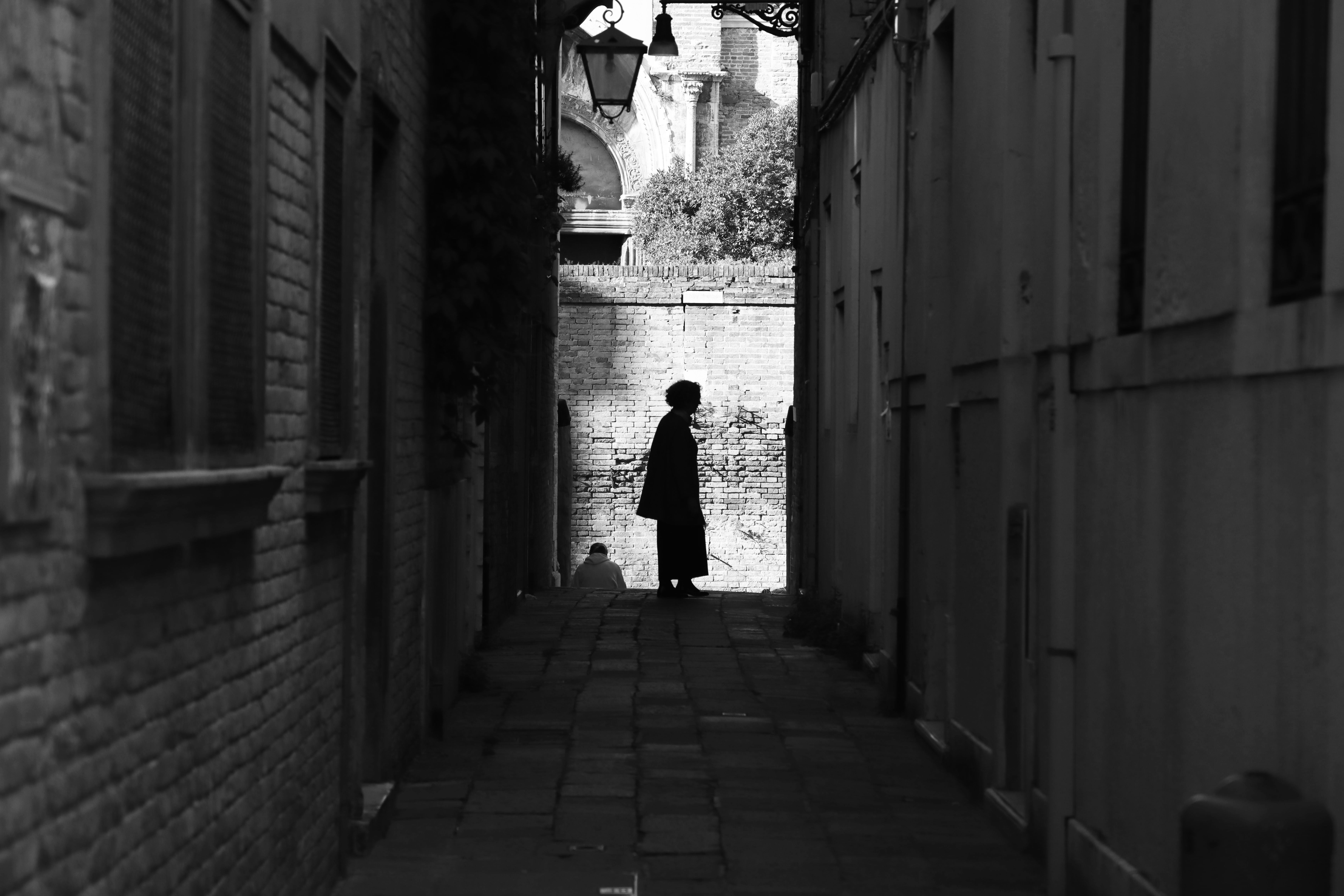 A woman walking down a narrow alleyway · Free Stock Photo