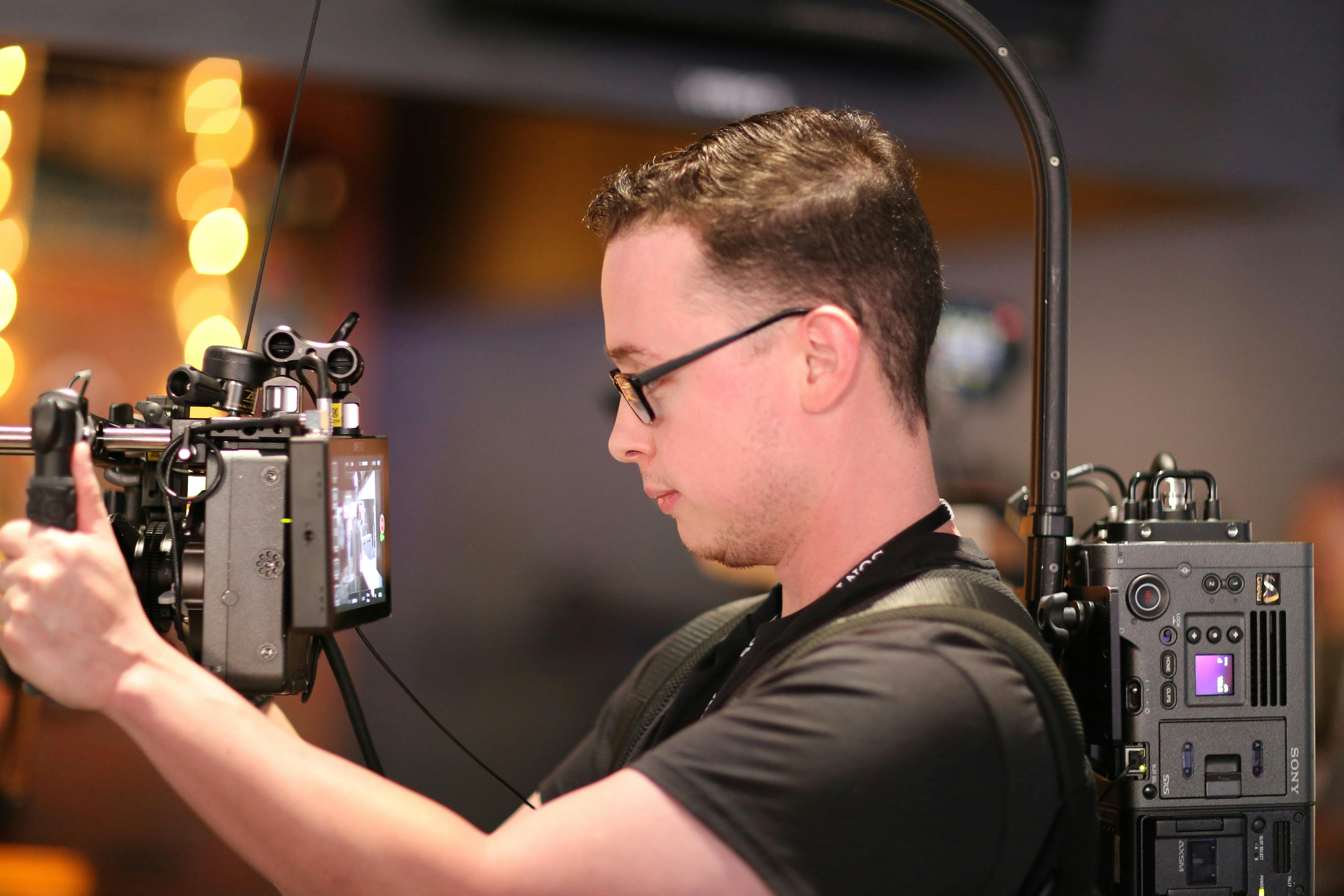 Man Holding a Broadcasting Camcorder · Free Stock Photo