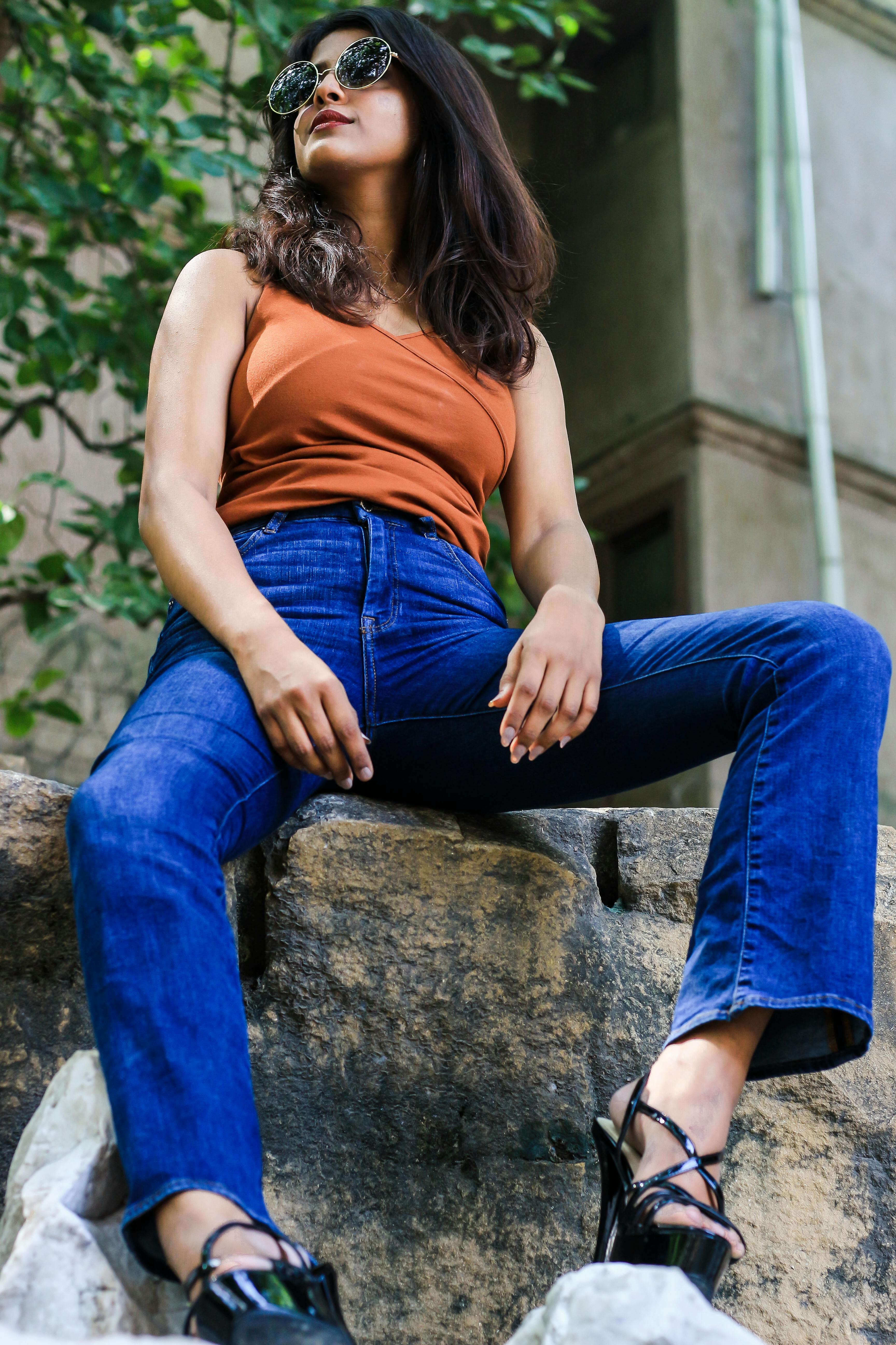 Woman Sitting on Rock Wearing Sunglasses · Free Stock Photo