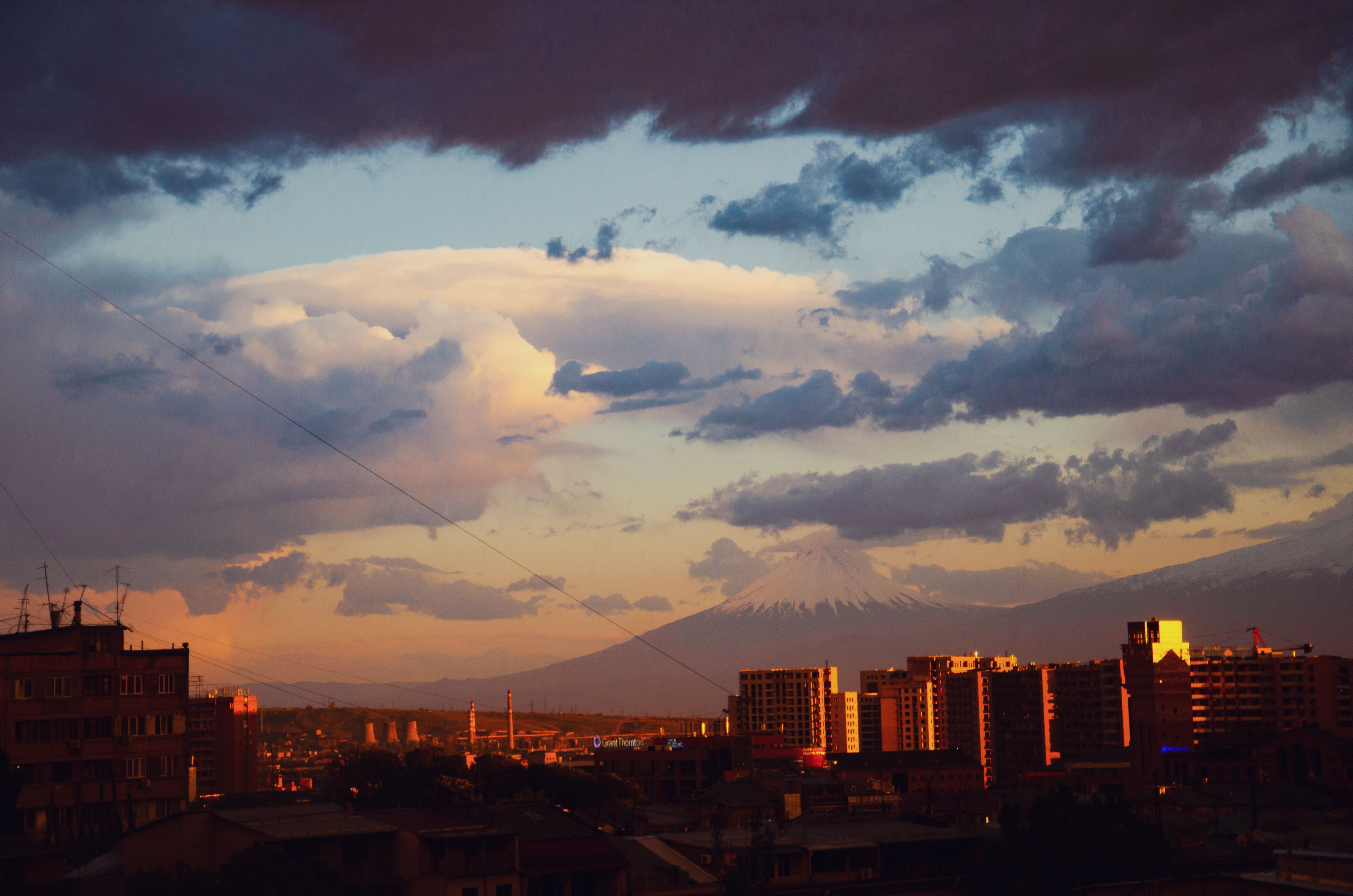 Skyline of a City in the Evening with the View of a Volcano in the ...
