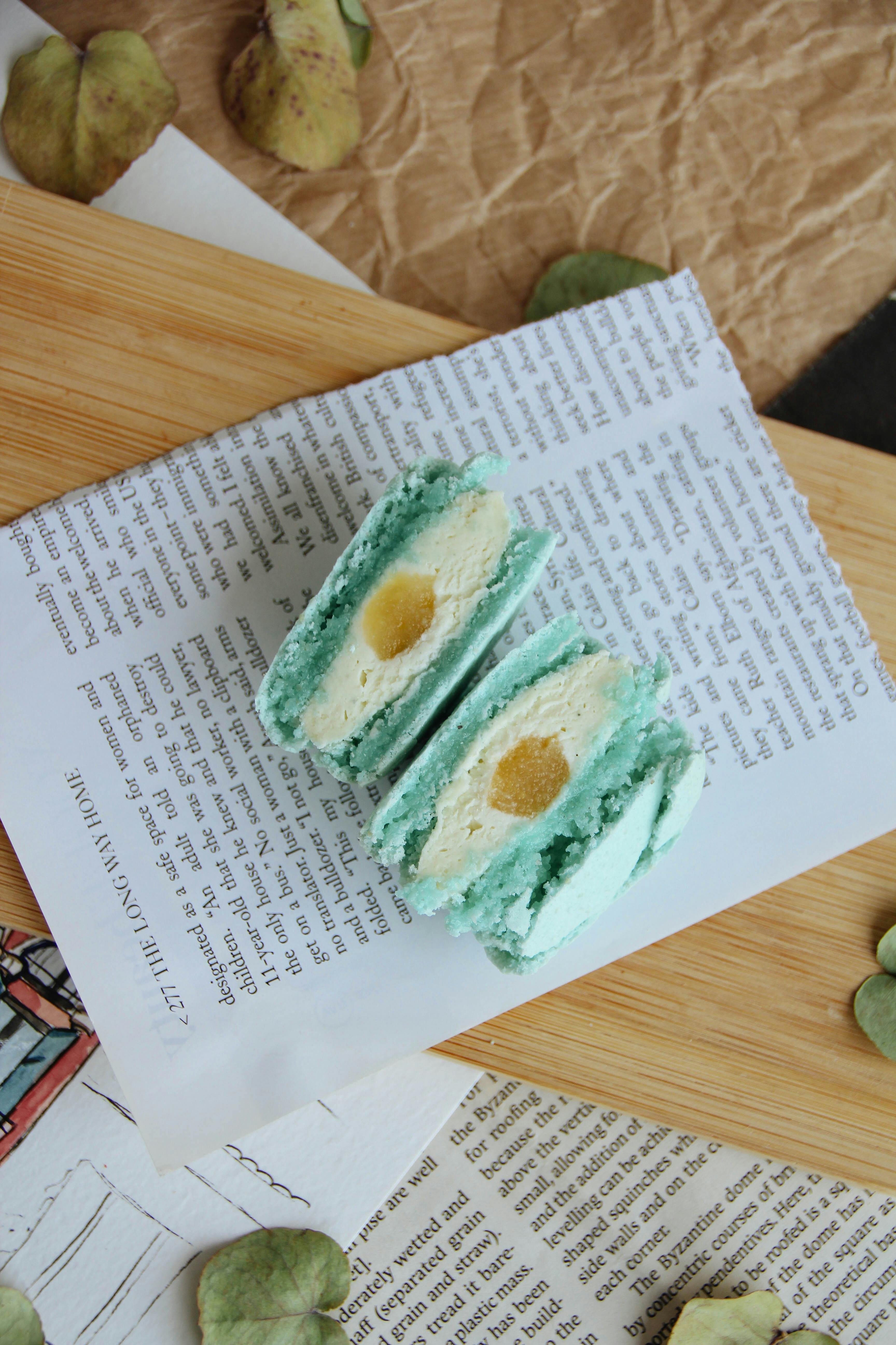 Cut Mint Green Macaron Pastries on a Paper Page · Free Stock Photo