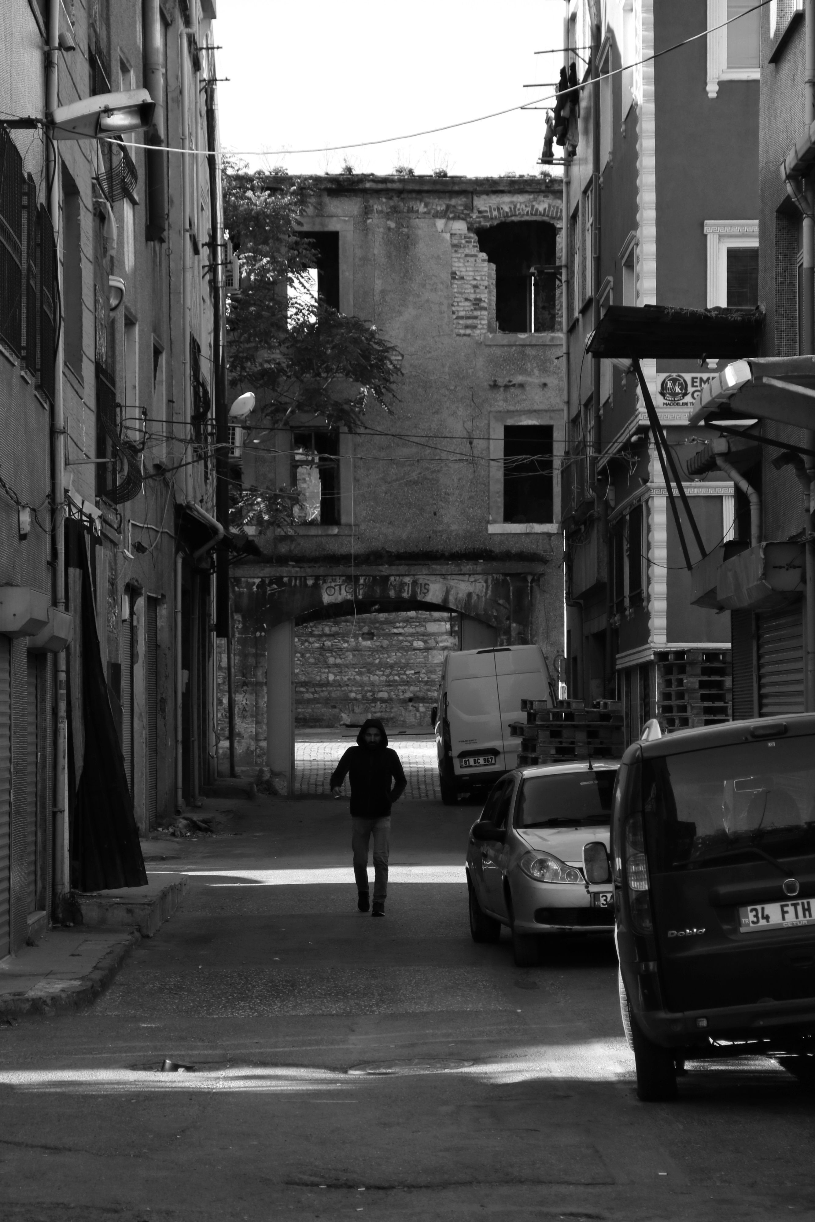 Man Walking on the Street between Buildings and Cars · Free Stock Photo