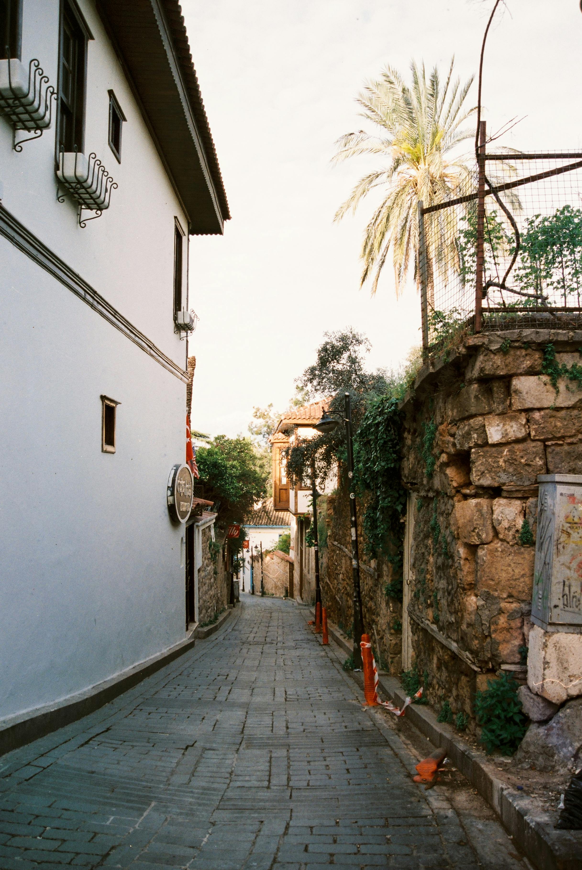 Concrete Road Between Wall And Houses · Free Stock Photo