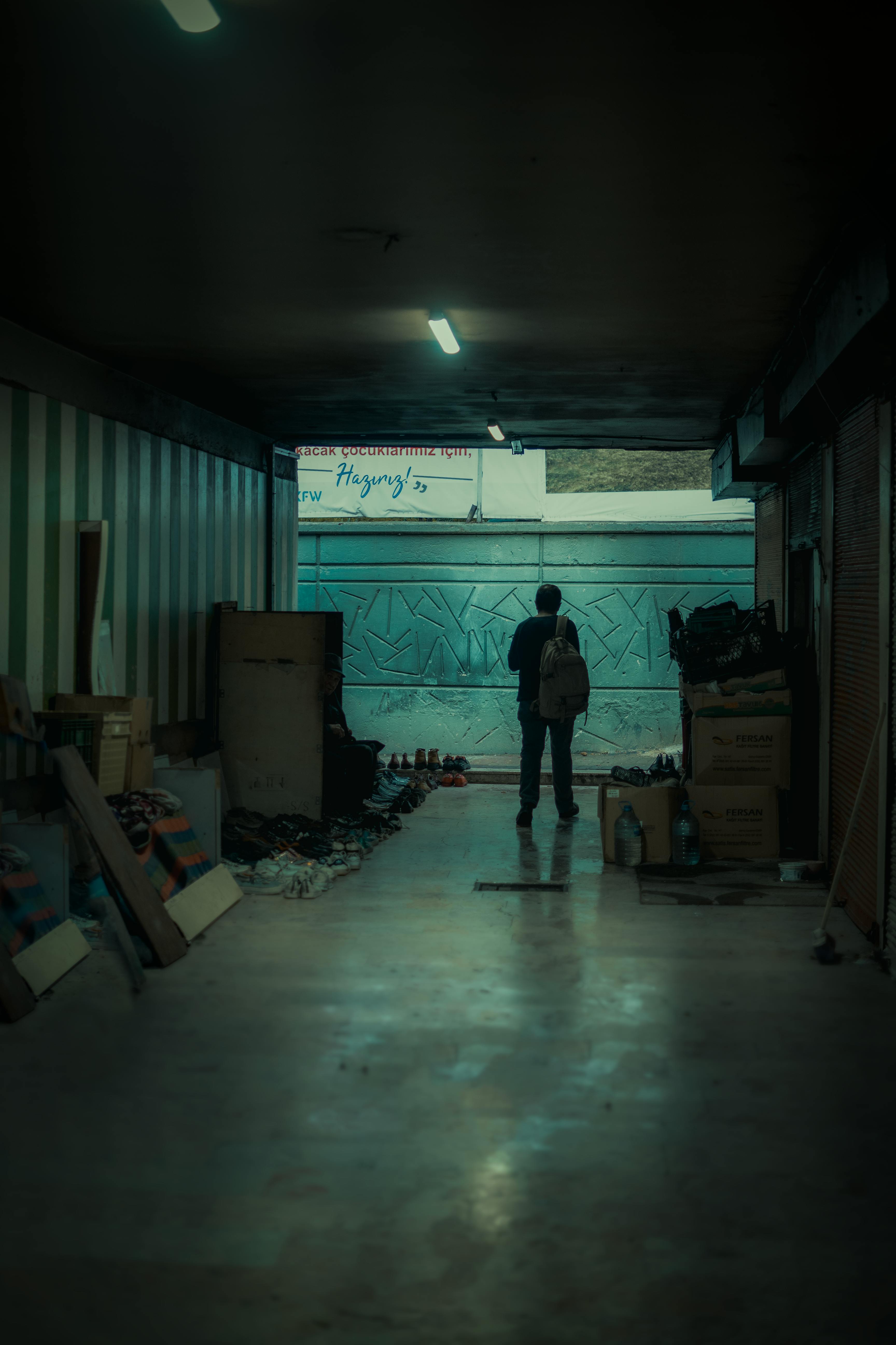 Man Waiting in a Cluttered Corridor · Free Stock Photo