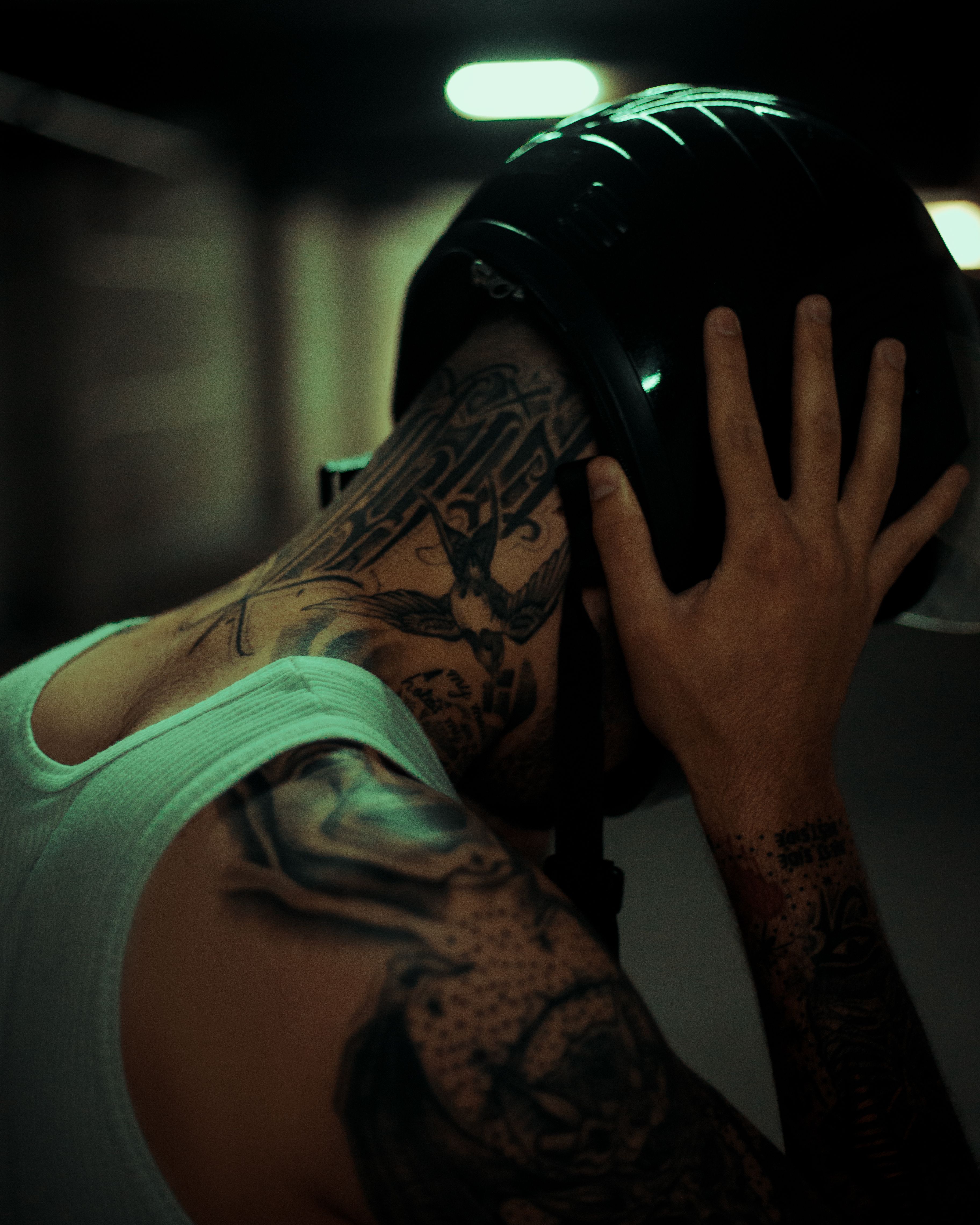 Tattooed Person Taking off Motorcycle Helmet · Free Stock Photo