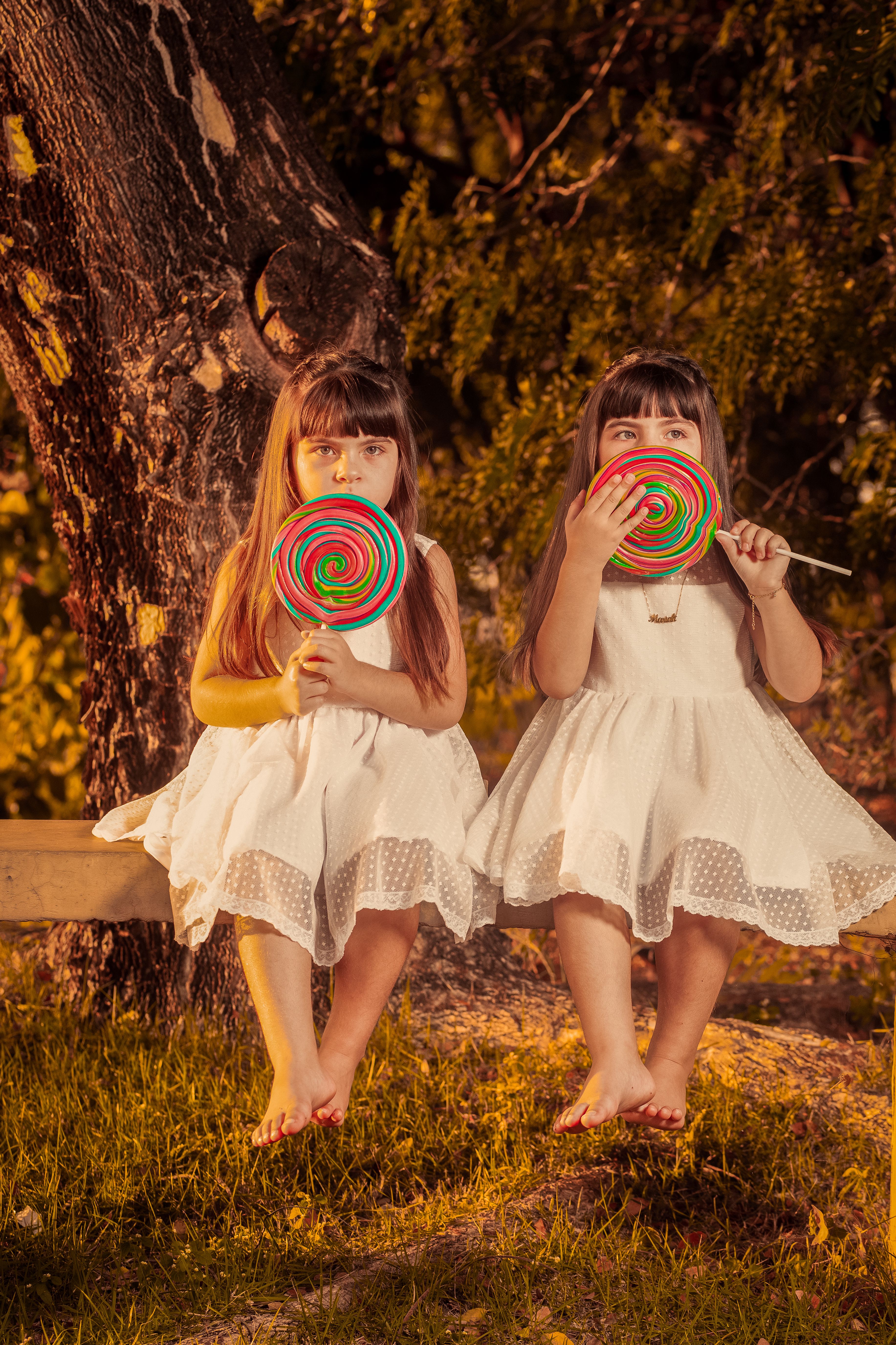 Two Little Girls Posing with Lollipops · Free Stock Photo