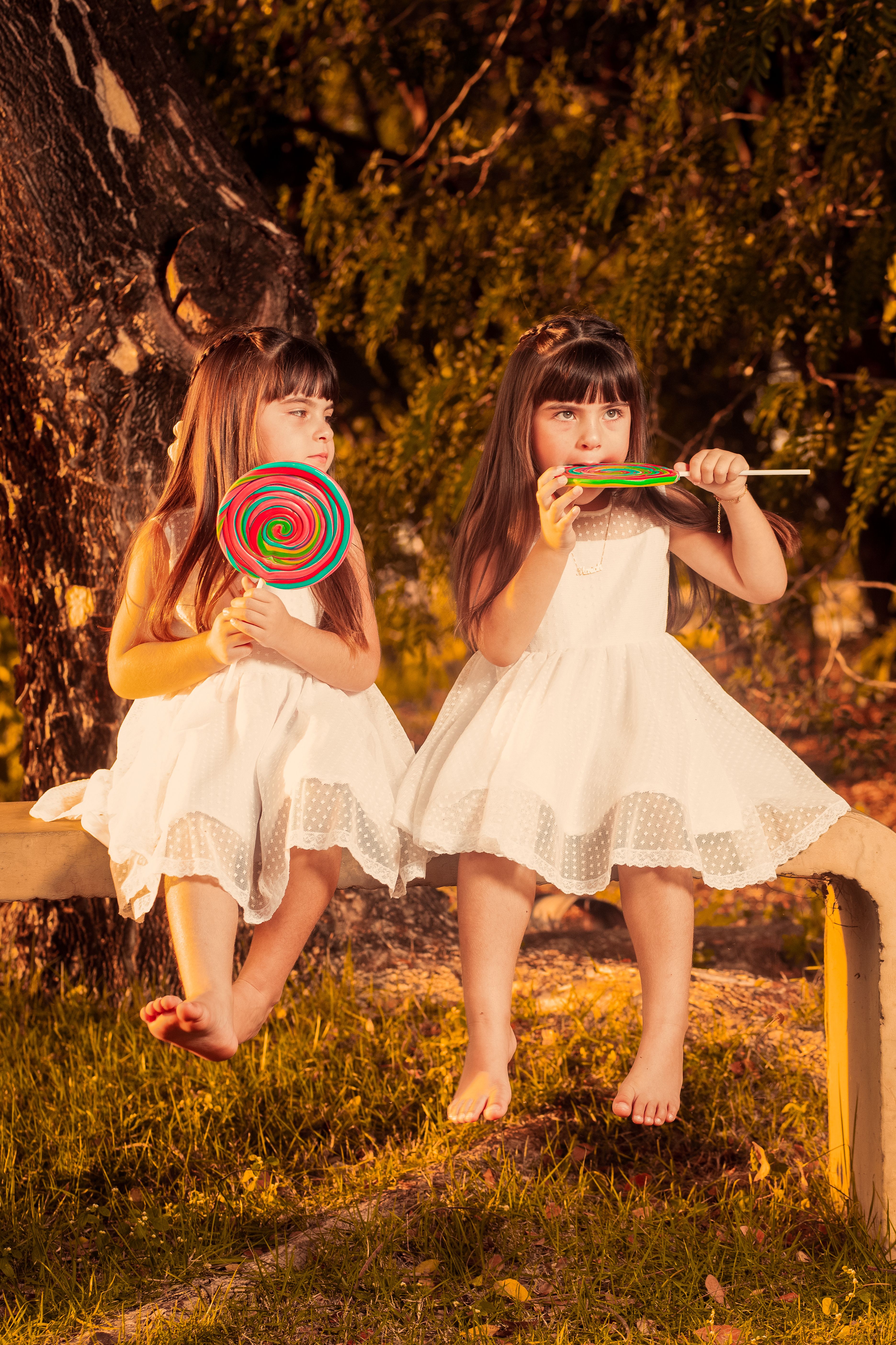 Two Little Girls Posing with Lollipops · Free Stock Photo