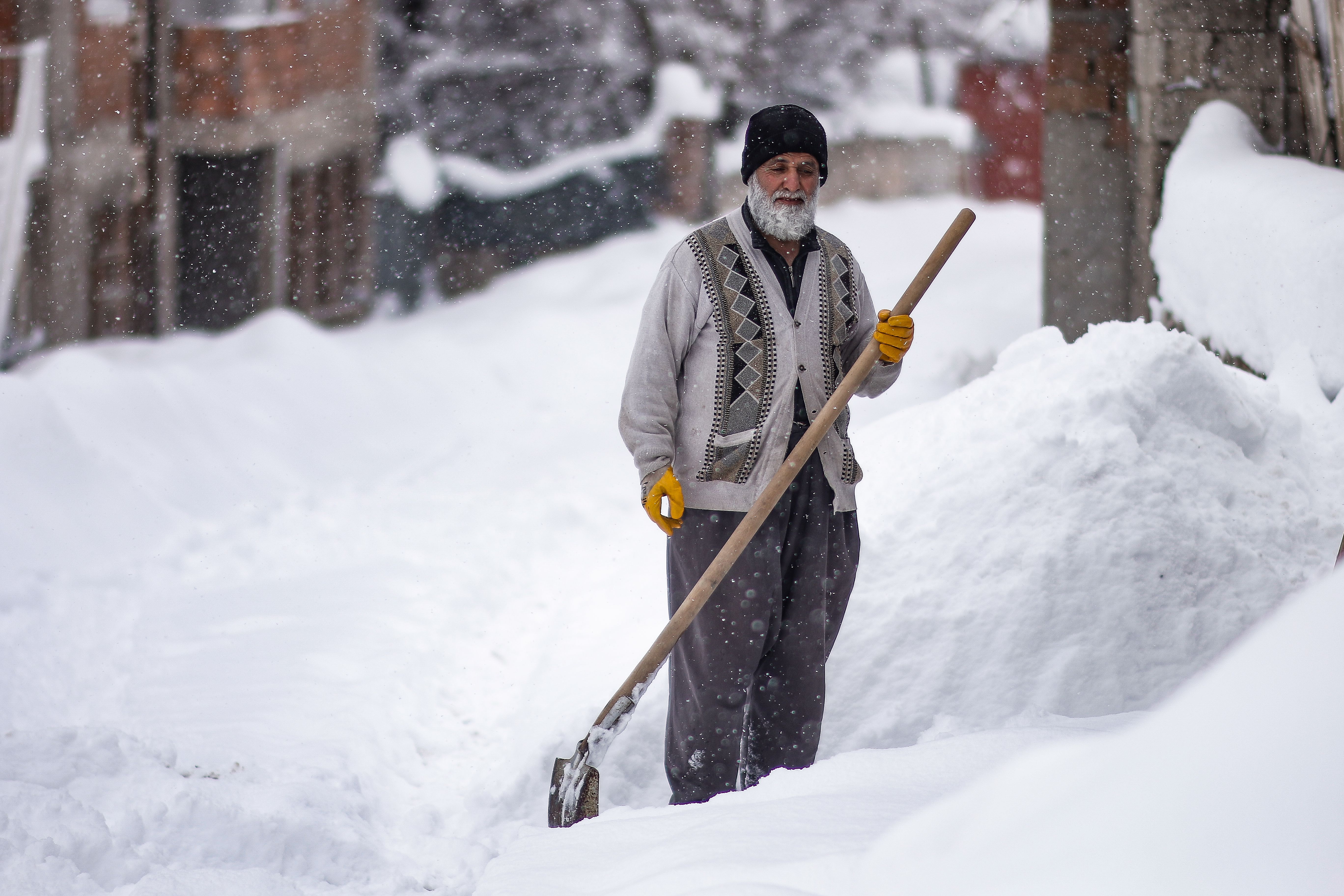 An Elderly Man Clearing Snow from the Street · Free Stock Photo