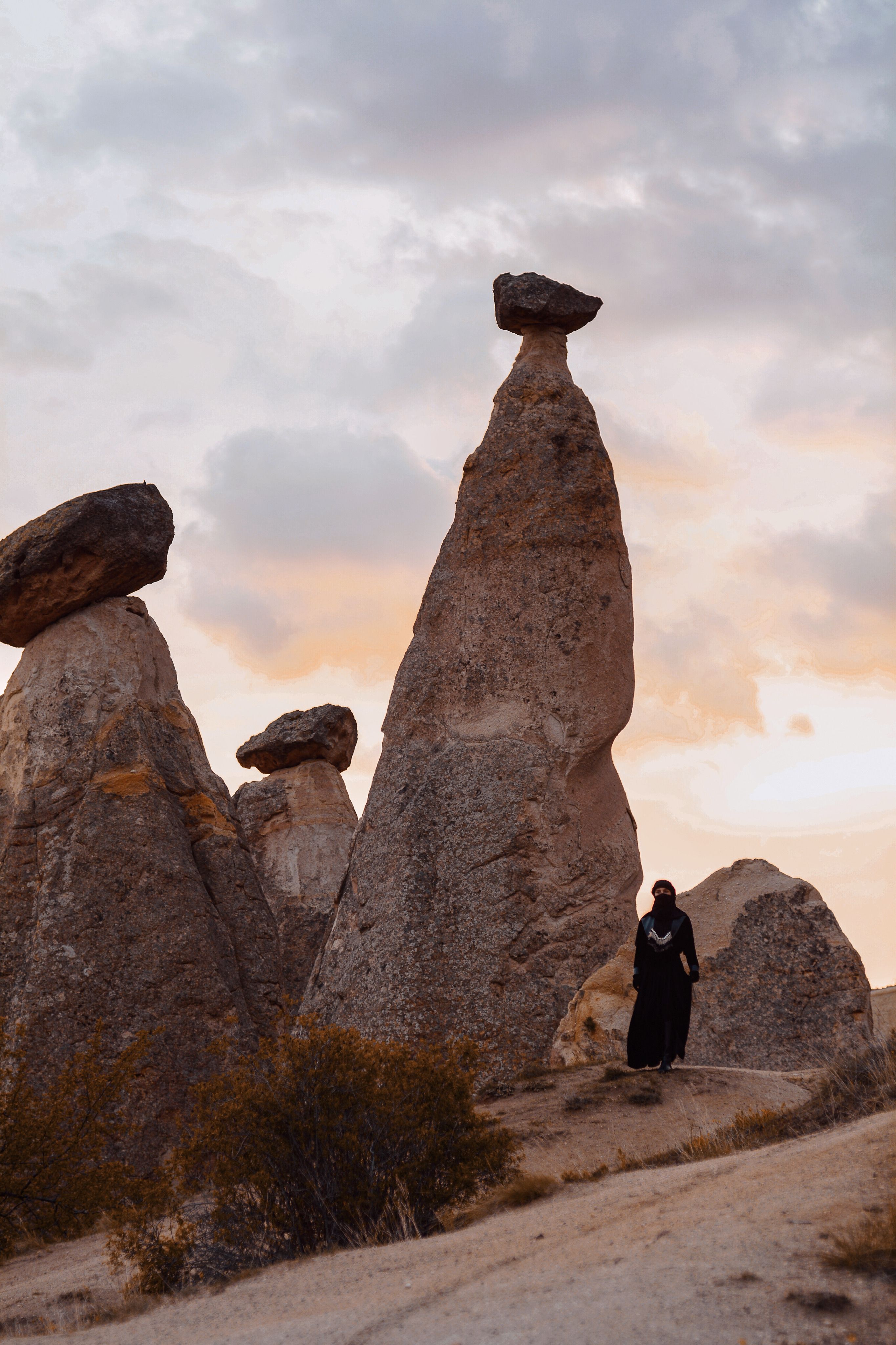 Person Standing by the Rock Formation at Sunset · Free Stock Photo