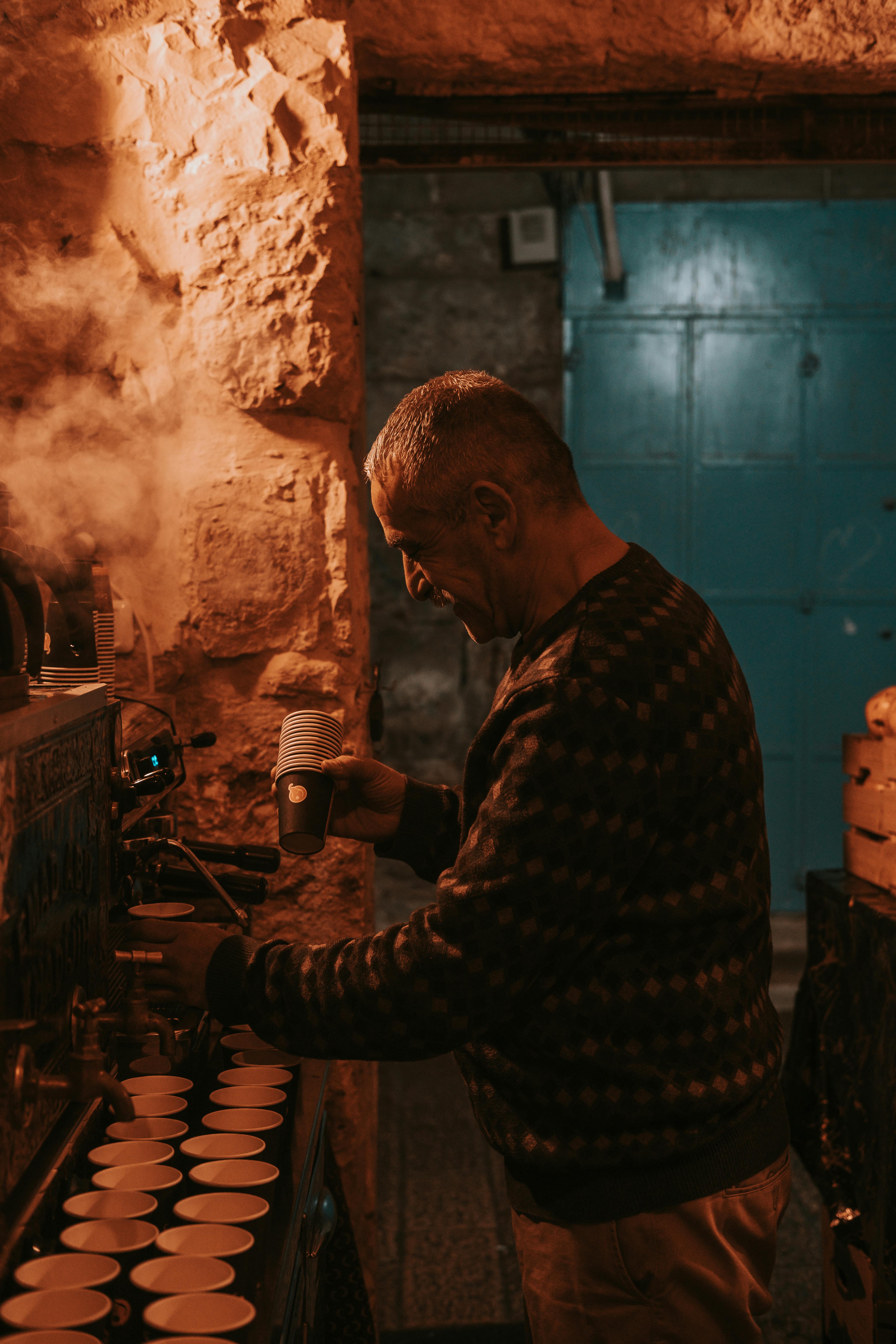 A man making coffee in a small room · Free Stock Photo