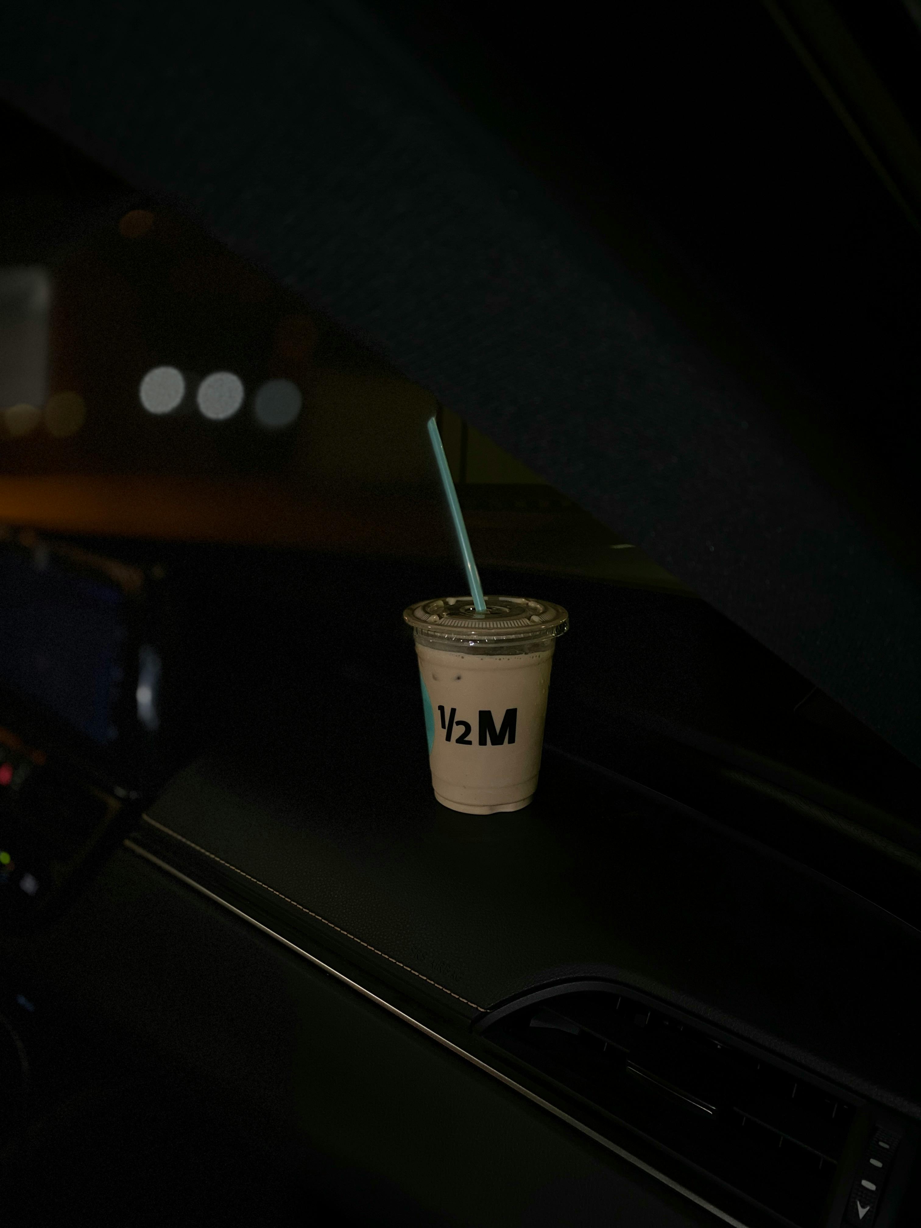 A Cup with a Milkshake Standing on a Dashboard in a Car · Free Stock Photo