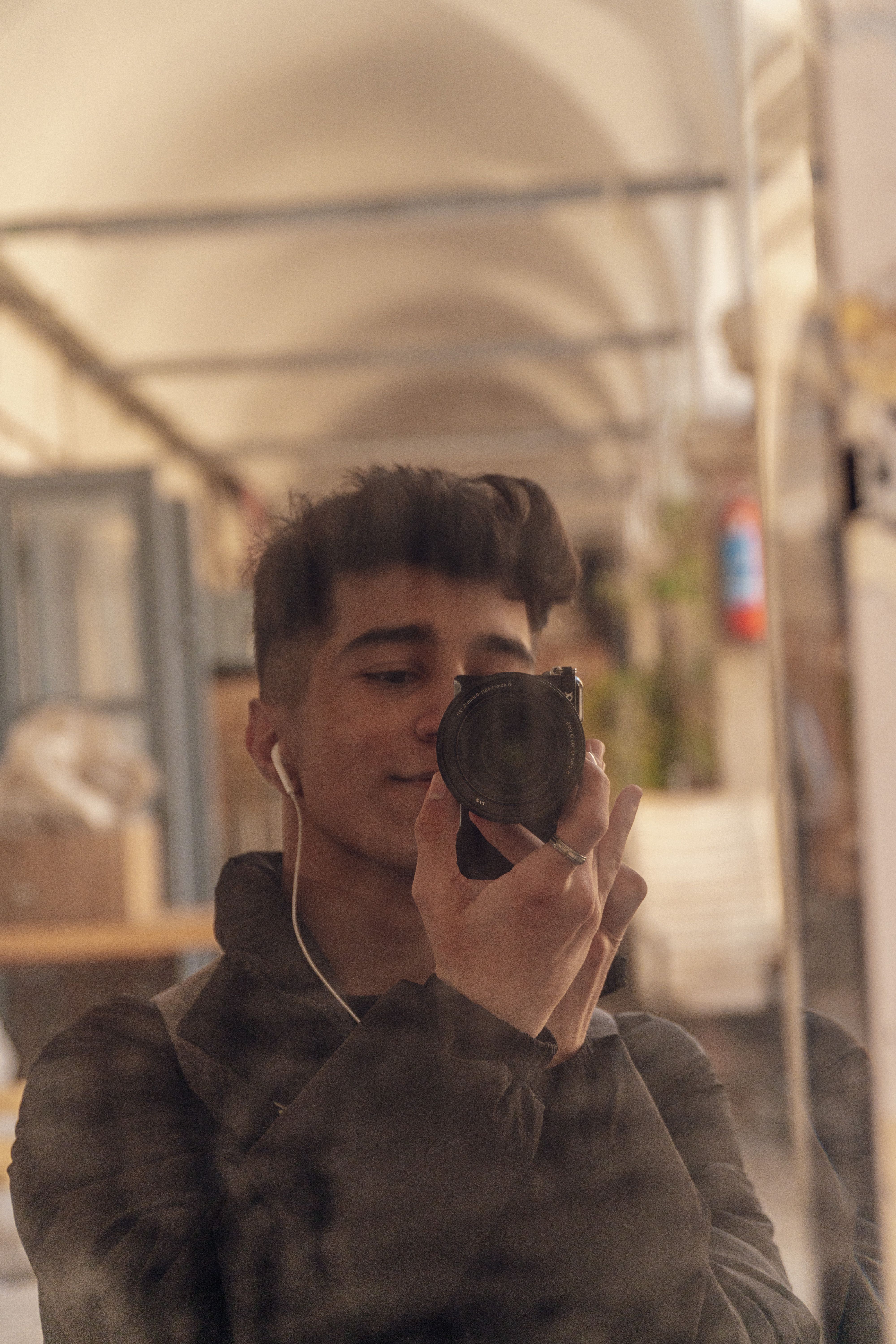 Young Man Taking a Mirror Selfie with a Camera · Free Stock Photo