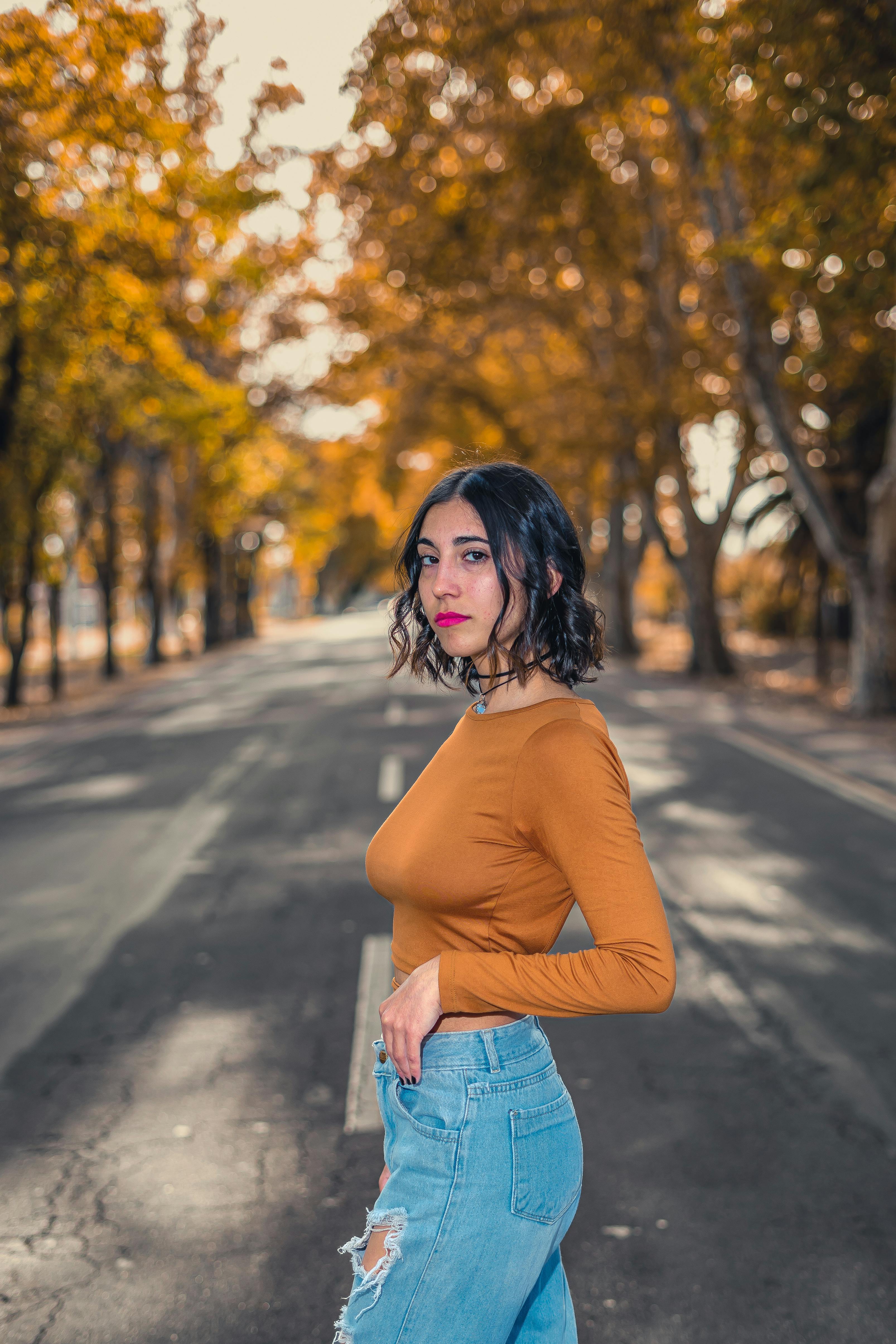 Young Woman Wearing Ripped Jeans Standing in the Middle of the Road ...