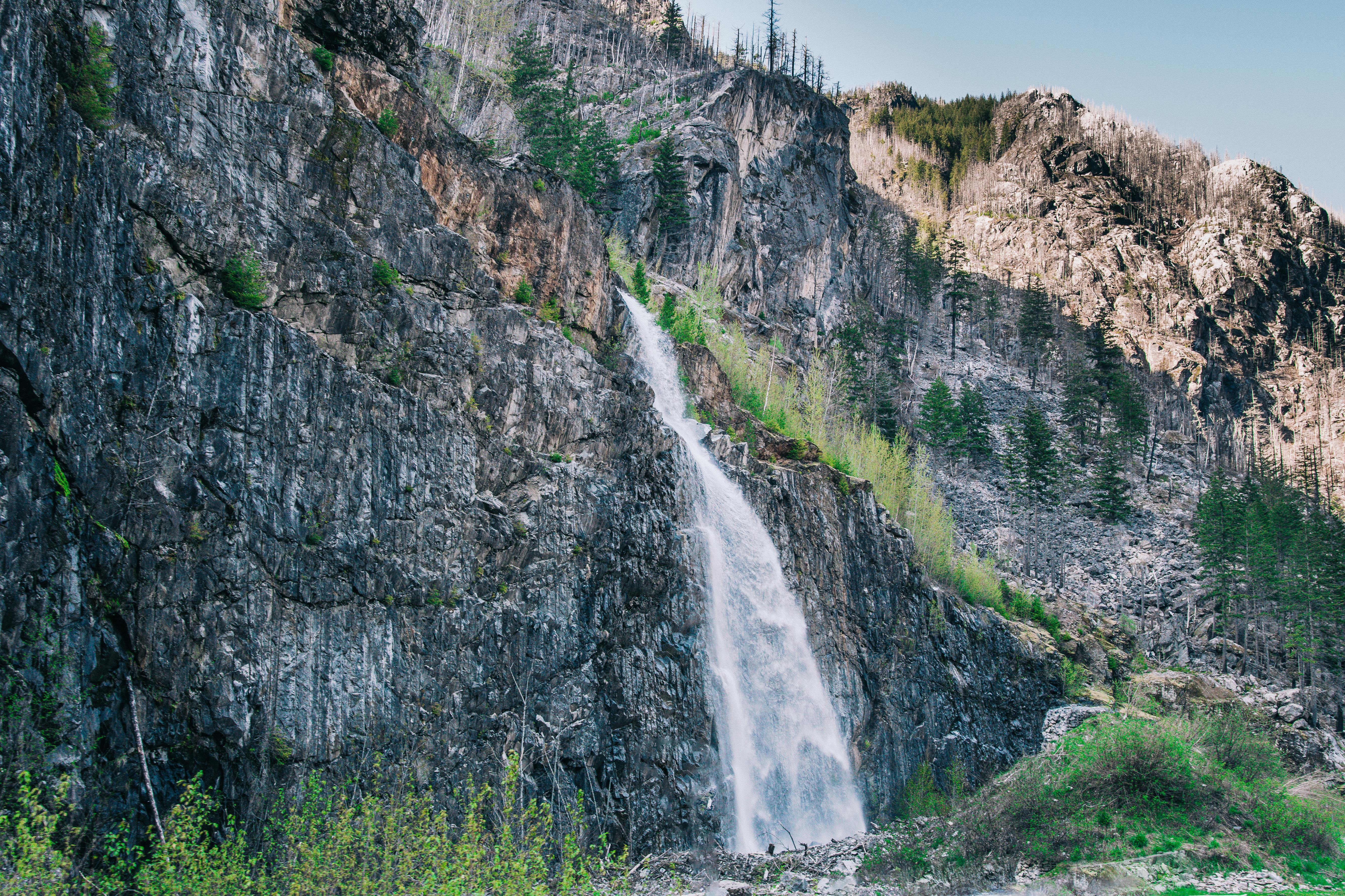 Steep Rock Formation with Waterfall · Free Stock Photo