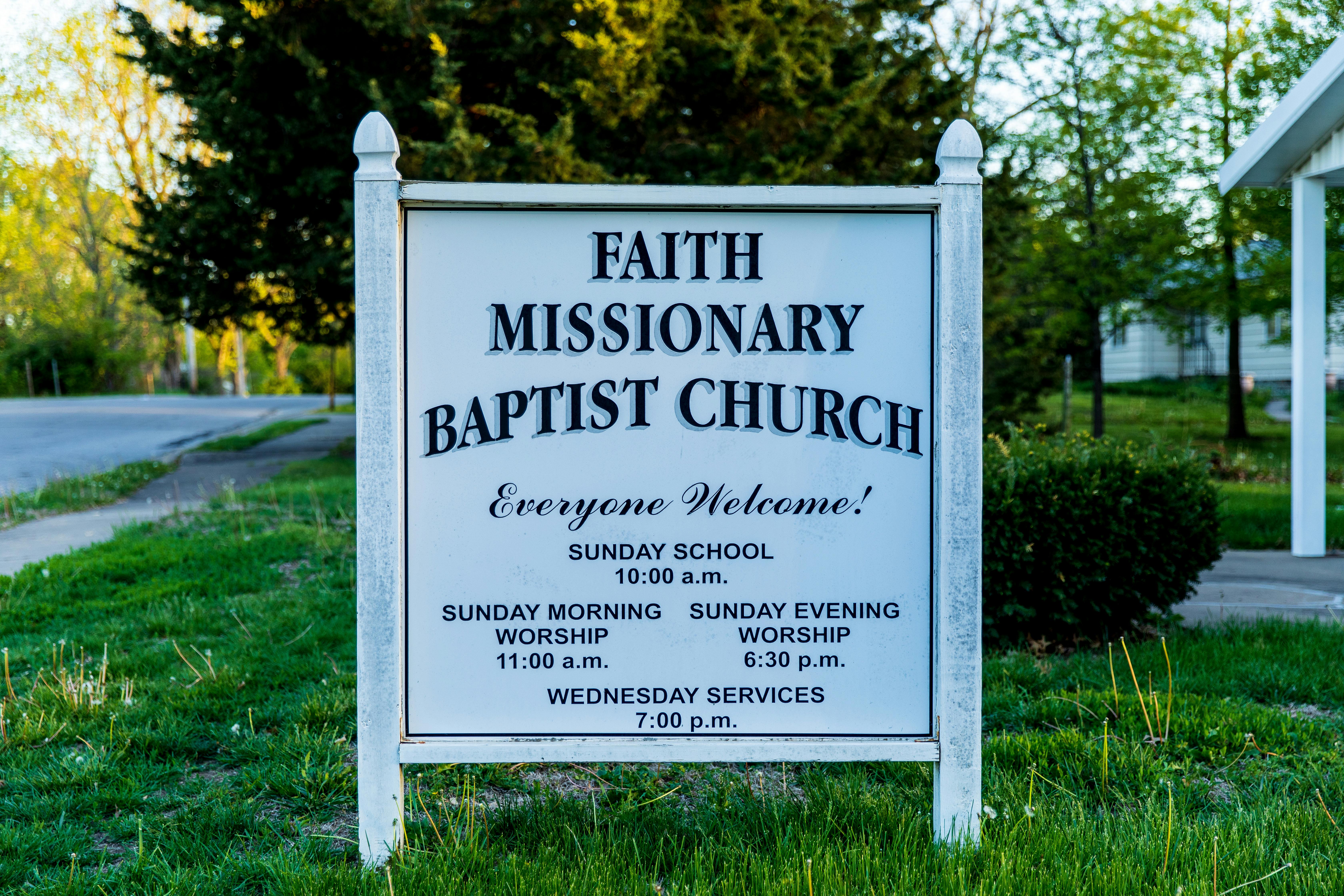 White Sign with a Church Opening Hours on a Roadside · Free Stock Photo