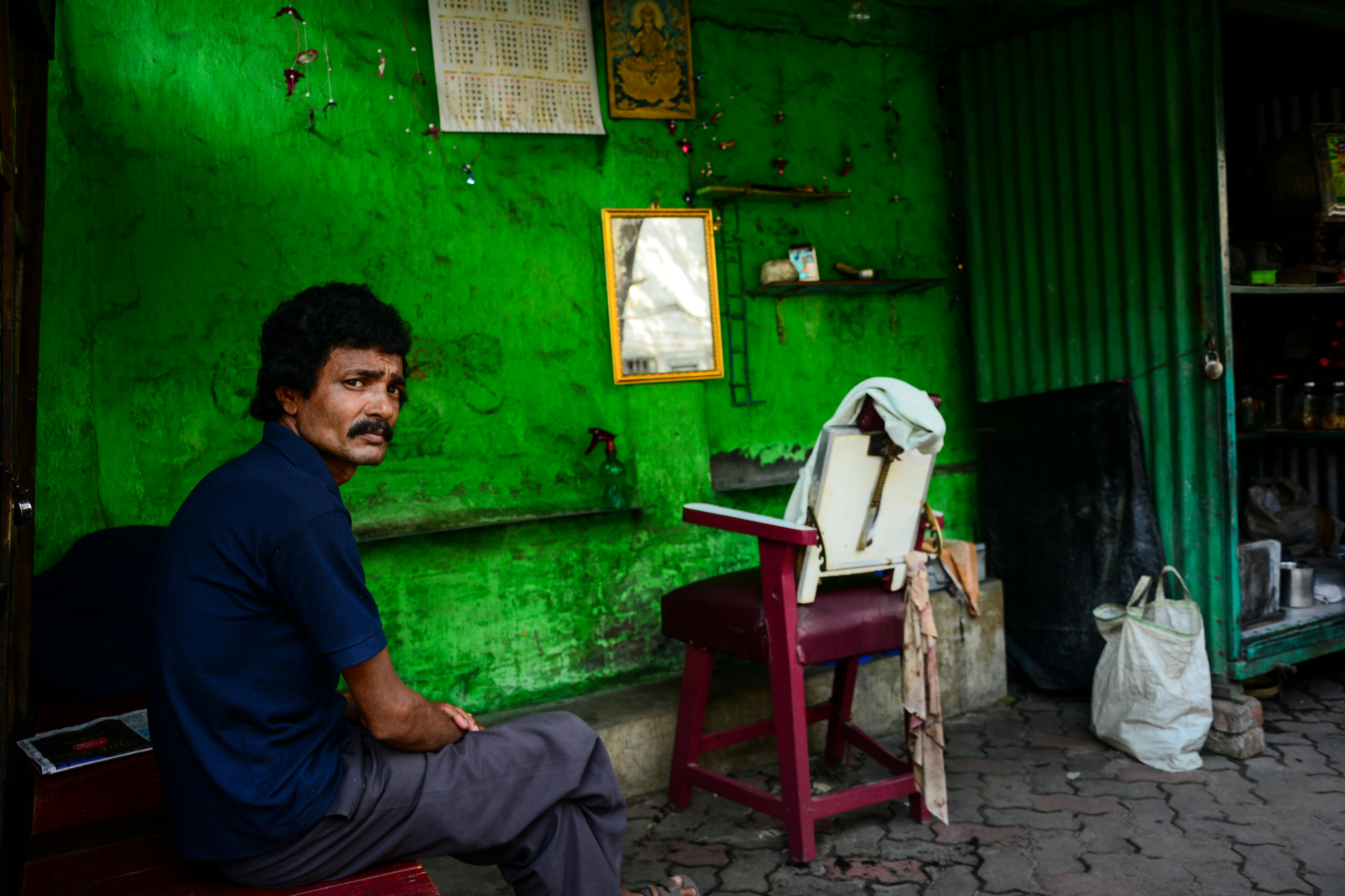 Man Sitting Inside Room Beside Chair · Free Stock Photo