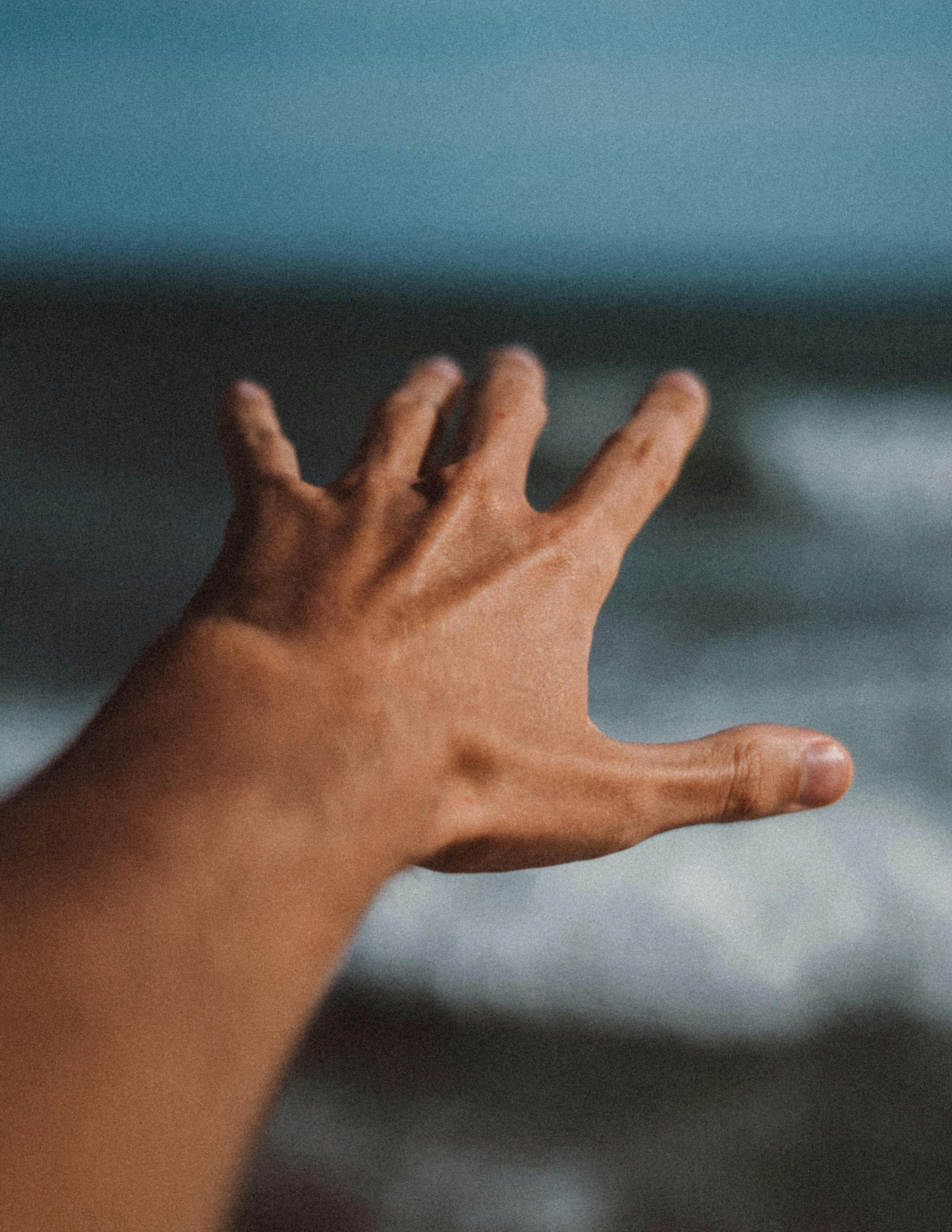 Photo of a Hand with the Sea in the Background · Free Stock Photo
