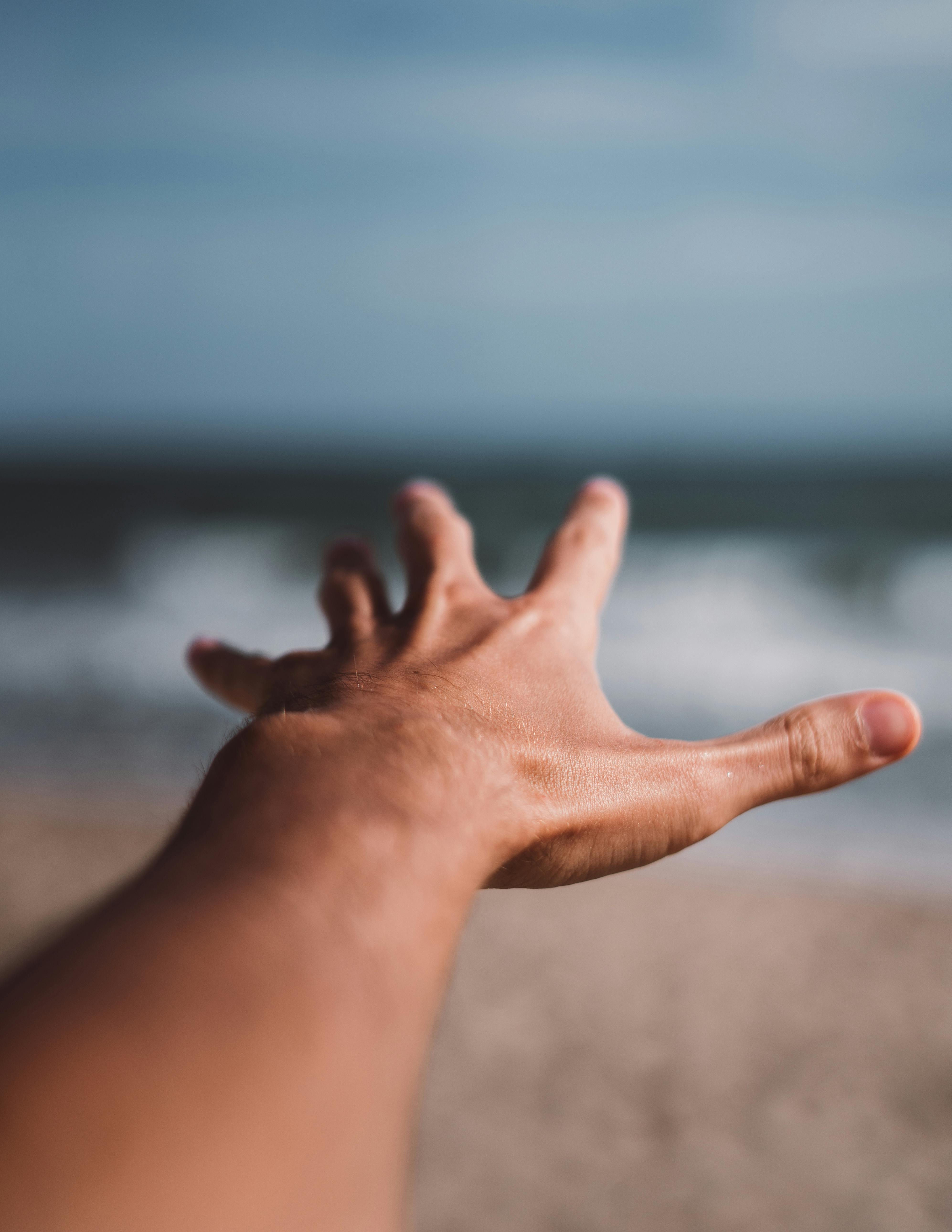 Photo of an Open Hand with the Sea and Beach in the Background · Free ...