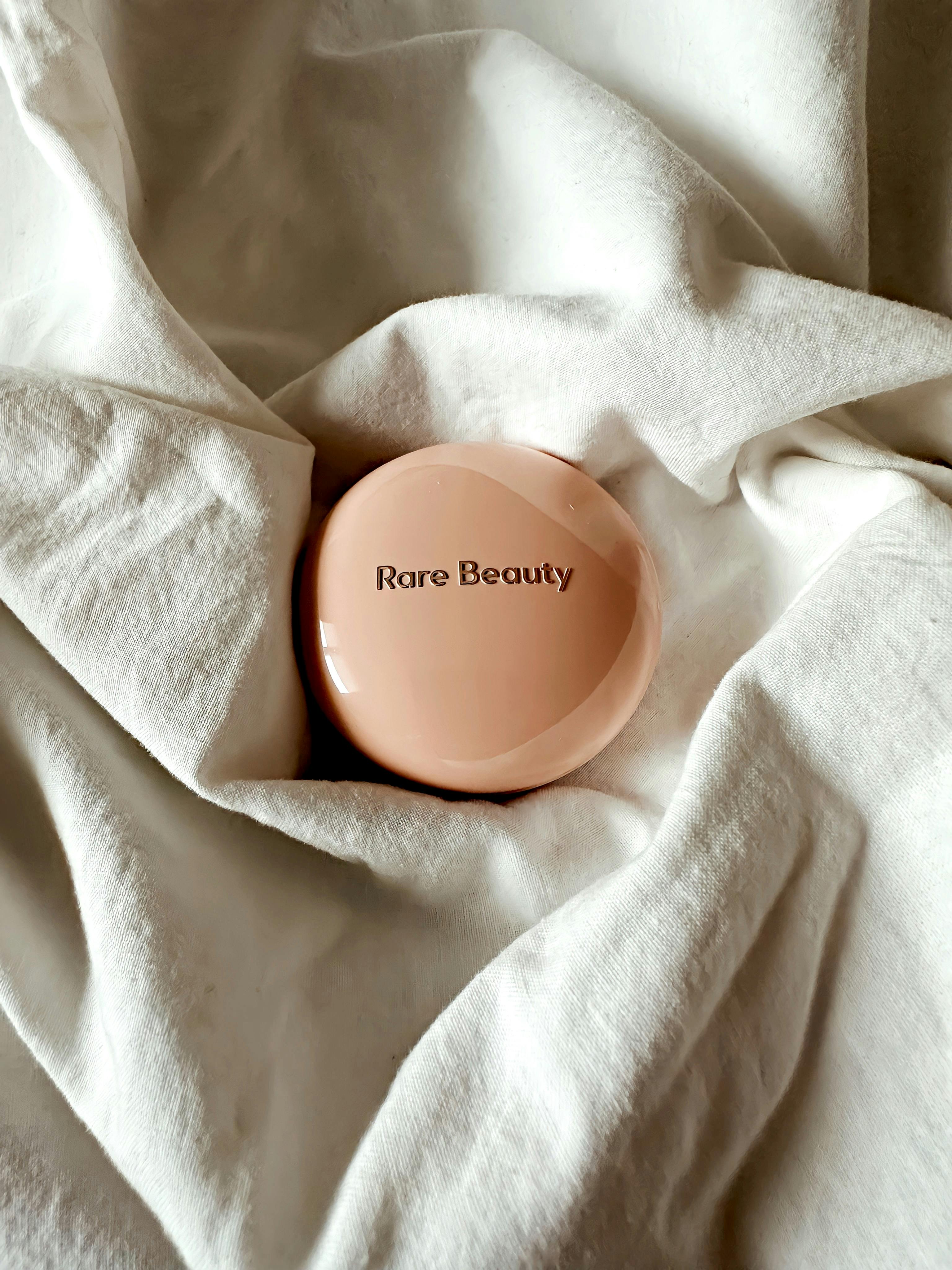 Rare Beauty Cosmetics Container on a White Cloth · Free Stock Photo