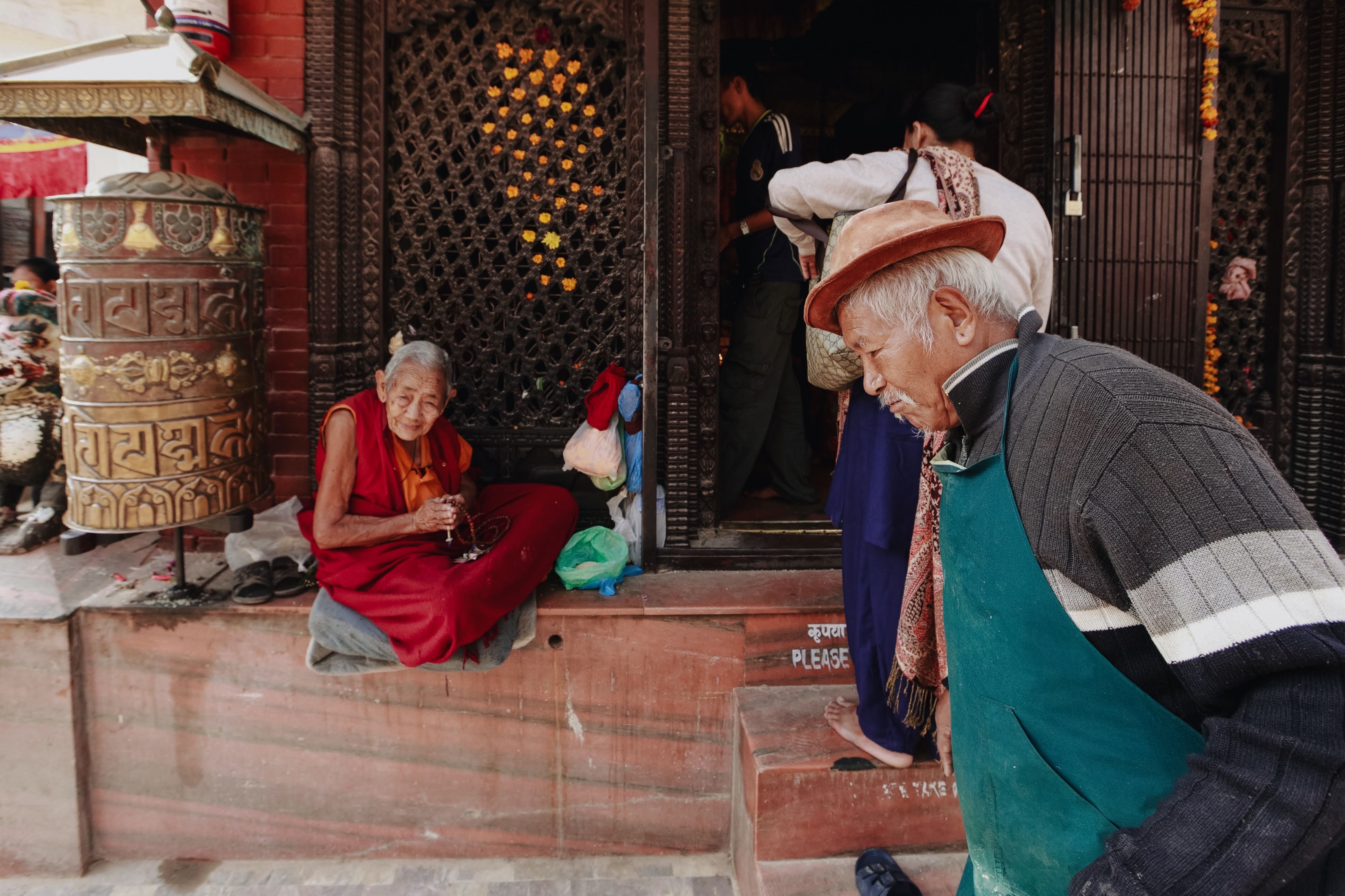 Monk in Red Gown Sitting by Street · Free Stock Photo
